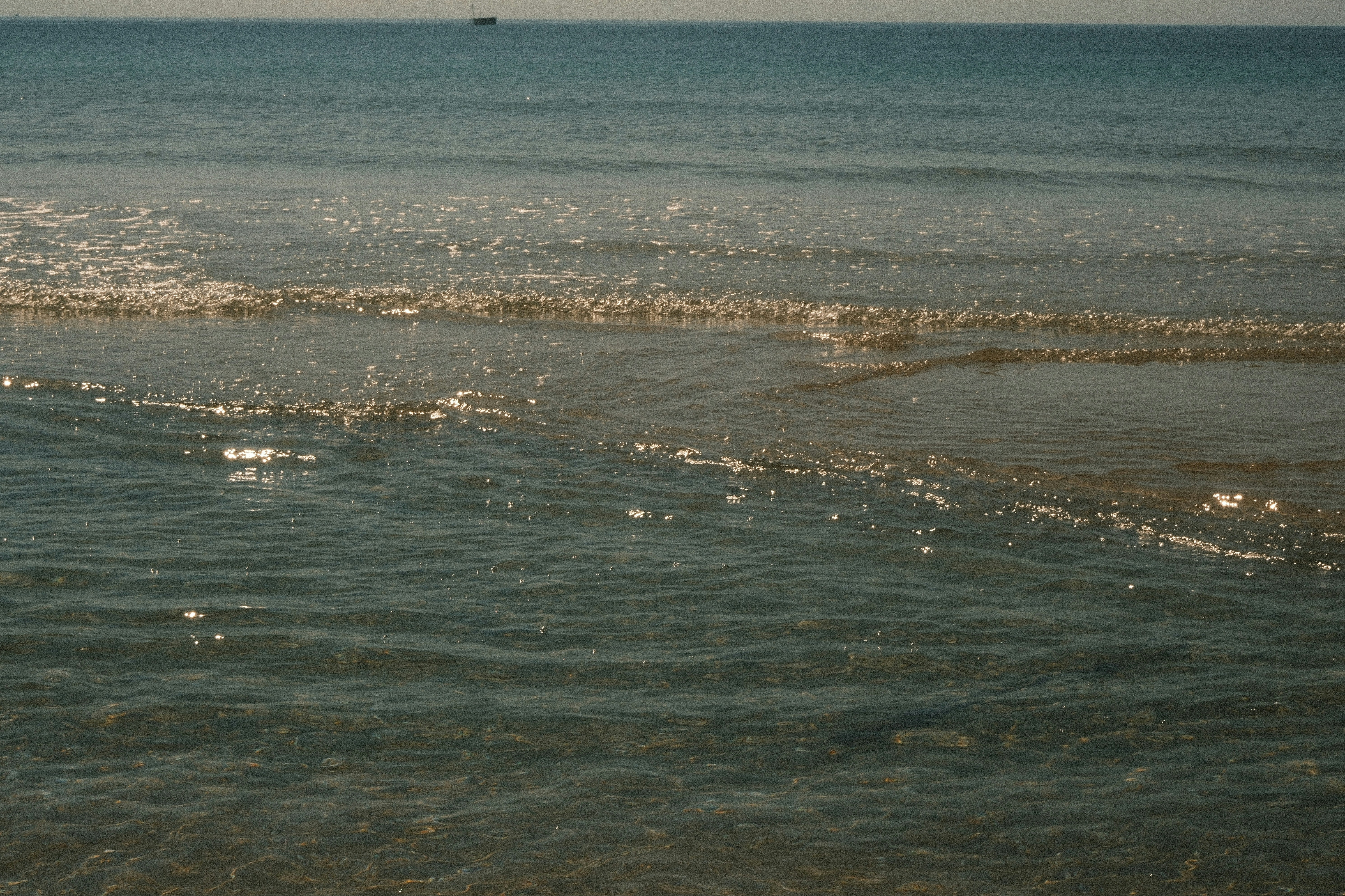Sunlit Ripple: A Quiet Moment over Clear Coastal Waters