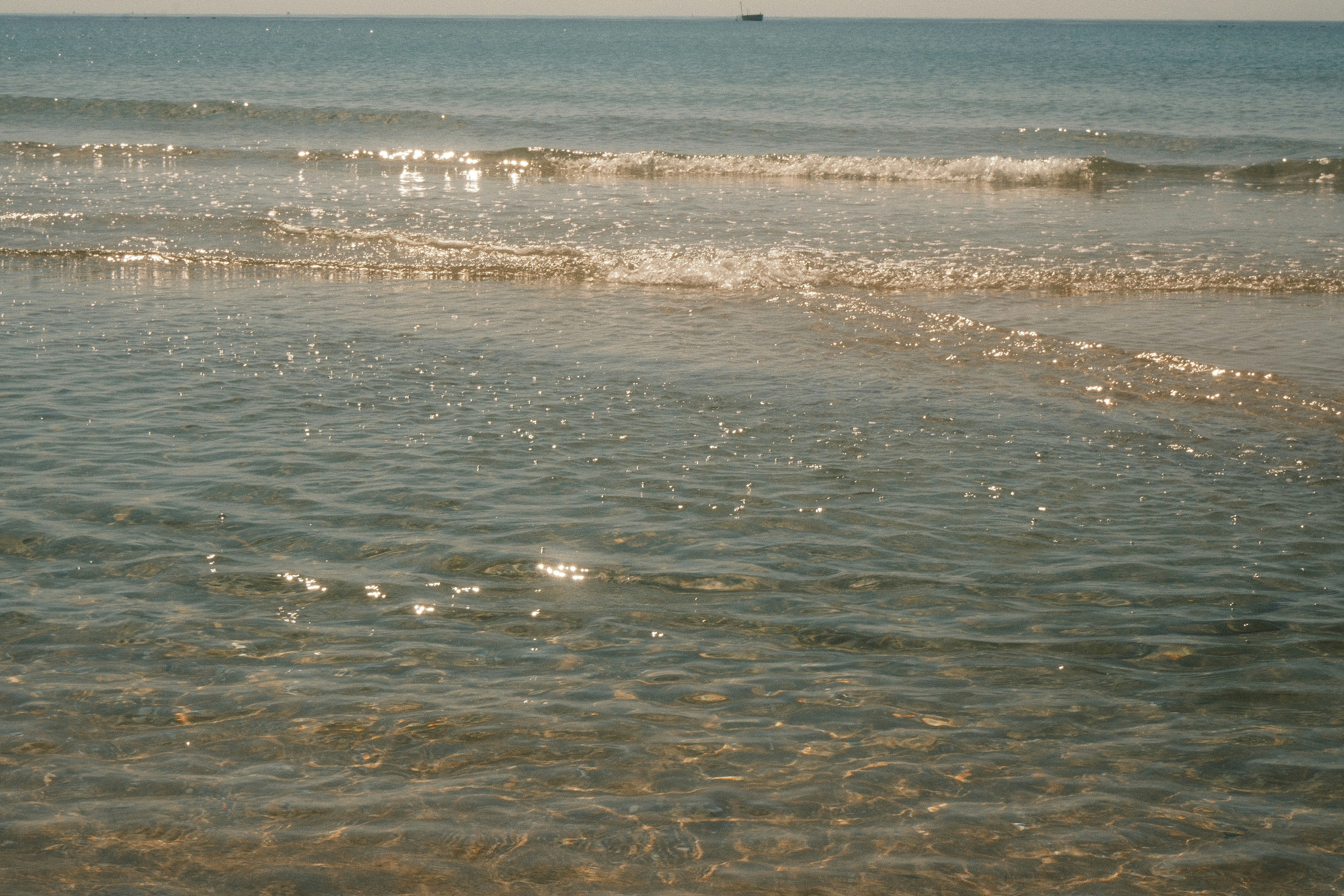 Glassy shoreline catching the last sunlit ripples