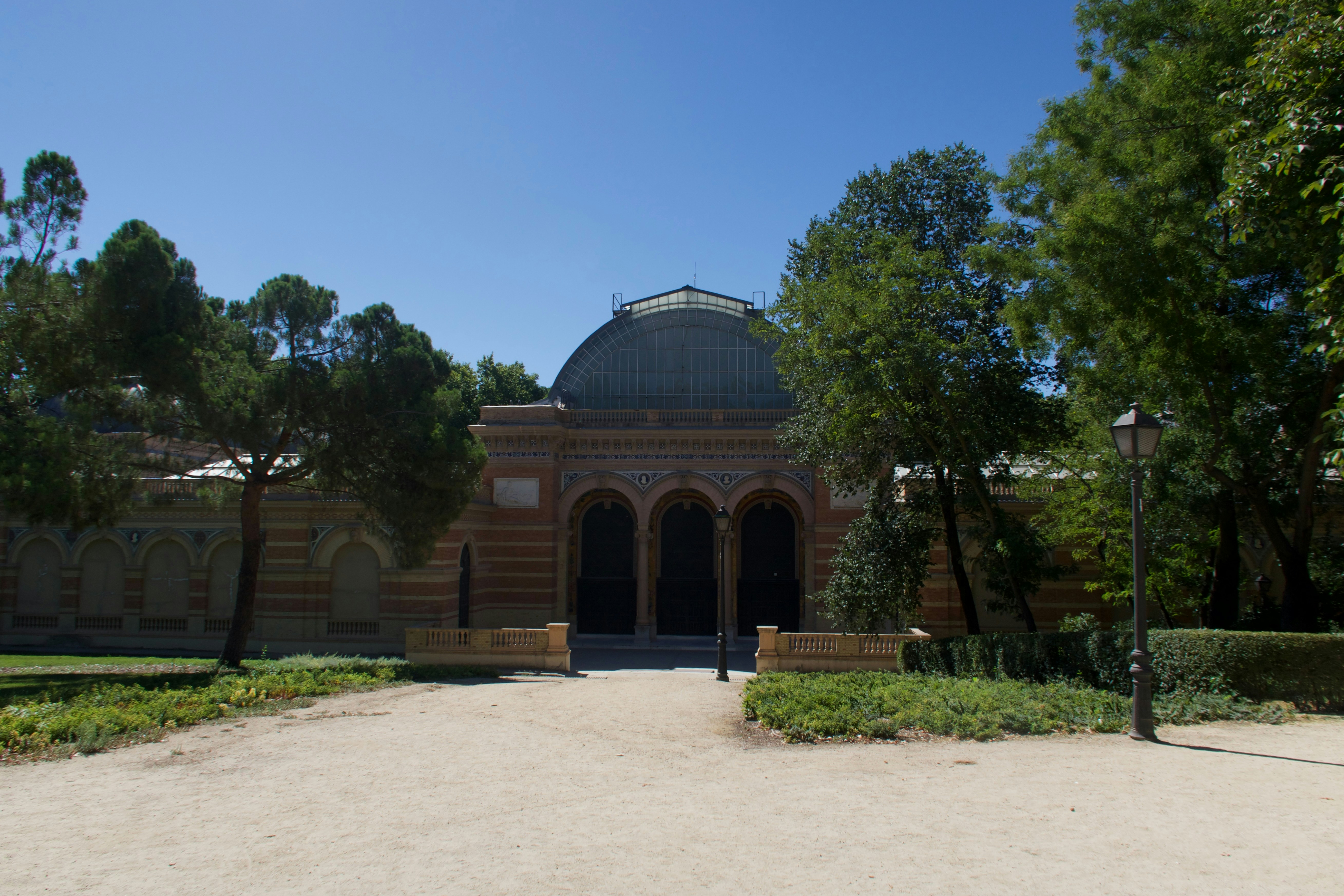 Glass Dome Beneath Shade: The Historic Building Framed by Trees
