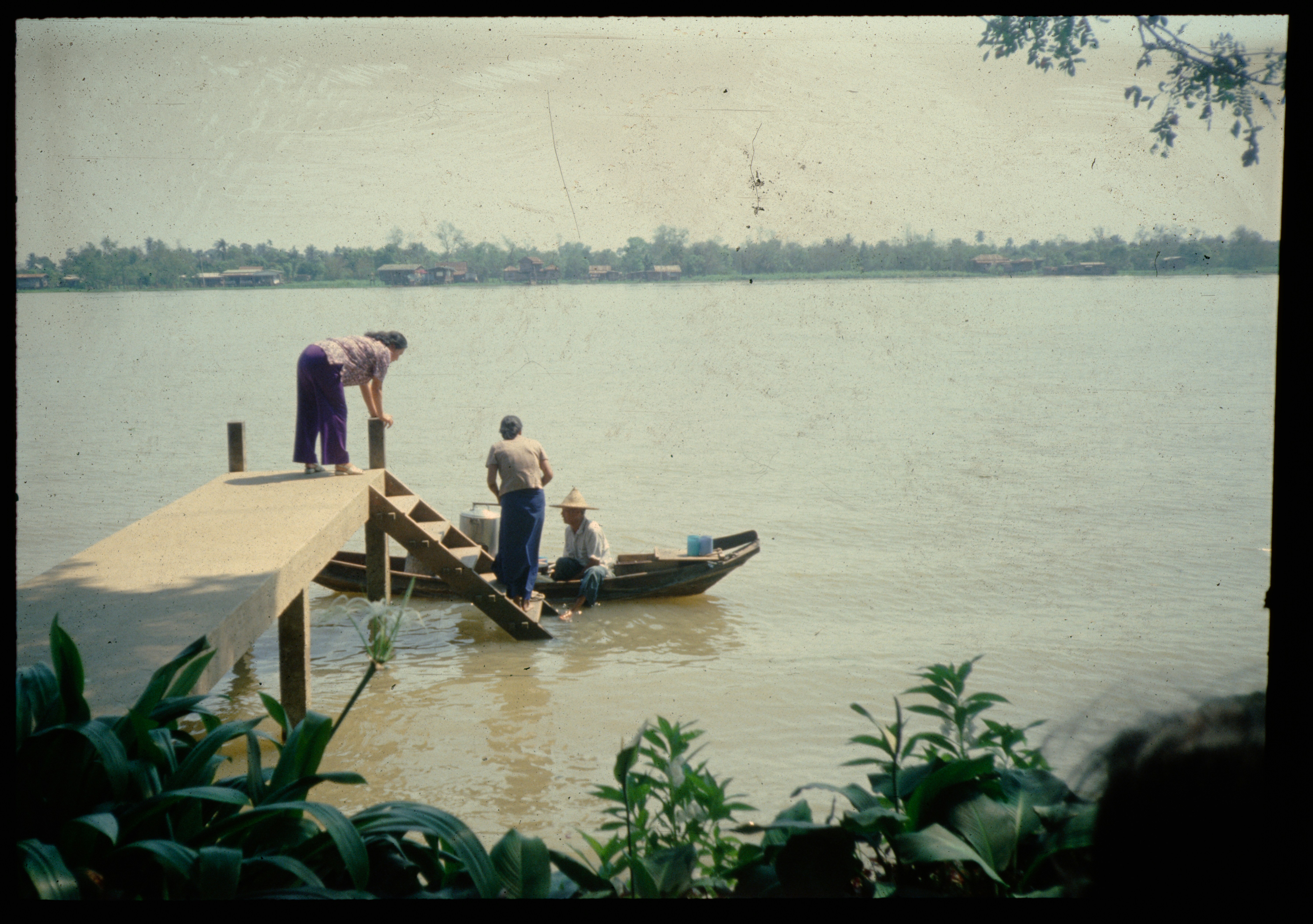 Dockside labor by the river: a small crew loading a boat at dusk