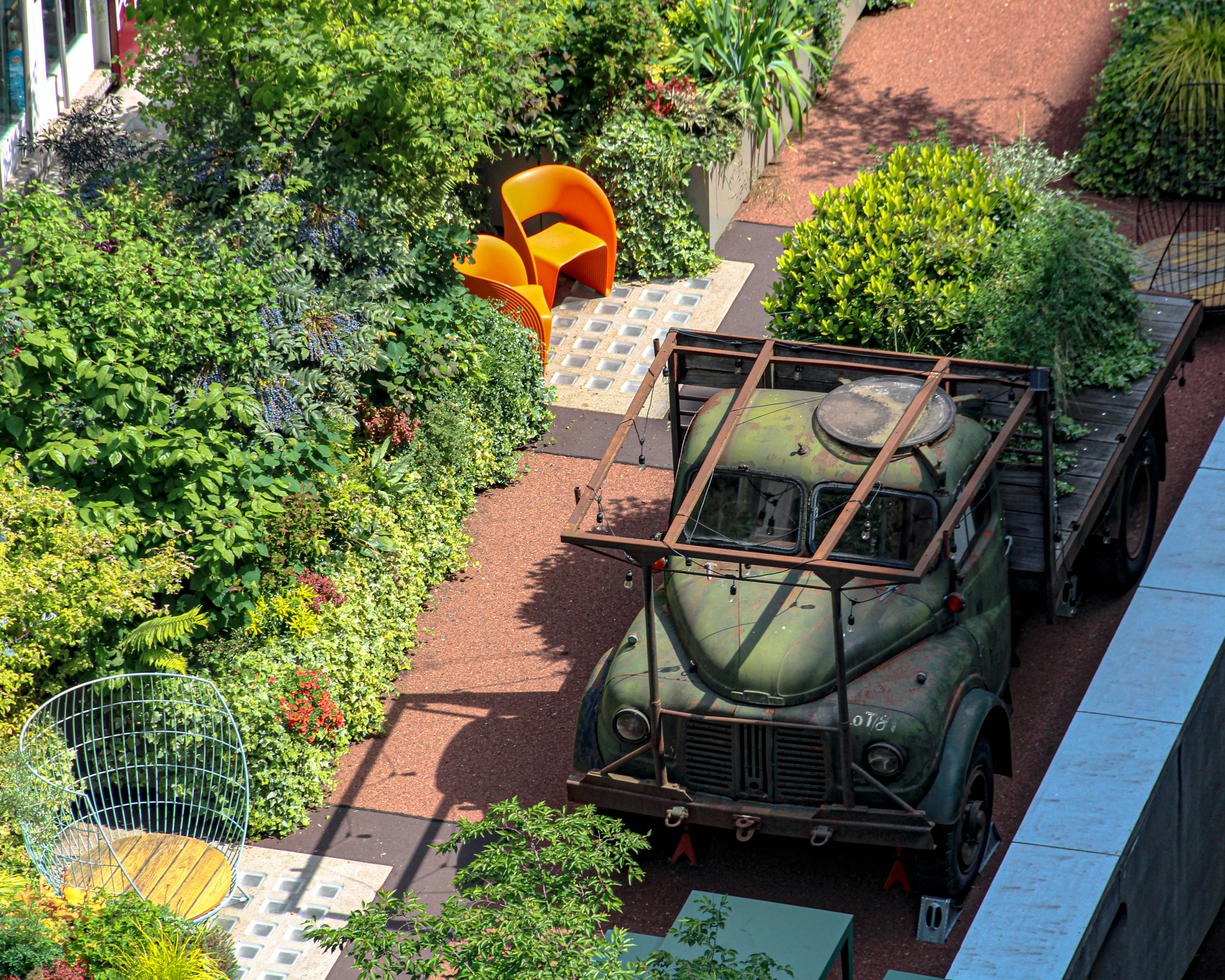Rusty Green Truck in a Lush Courtyard