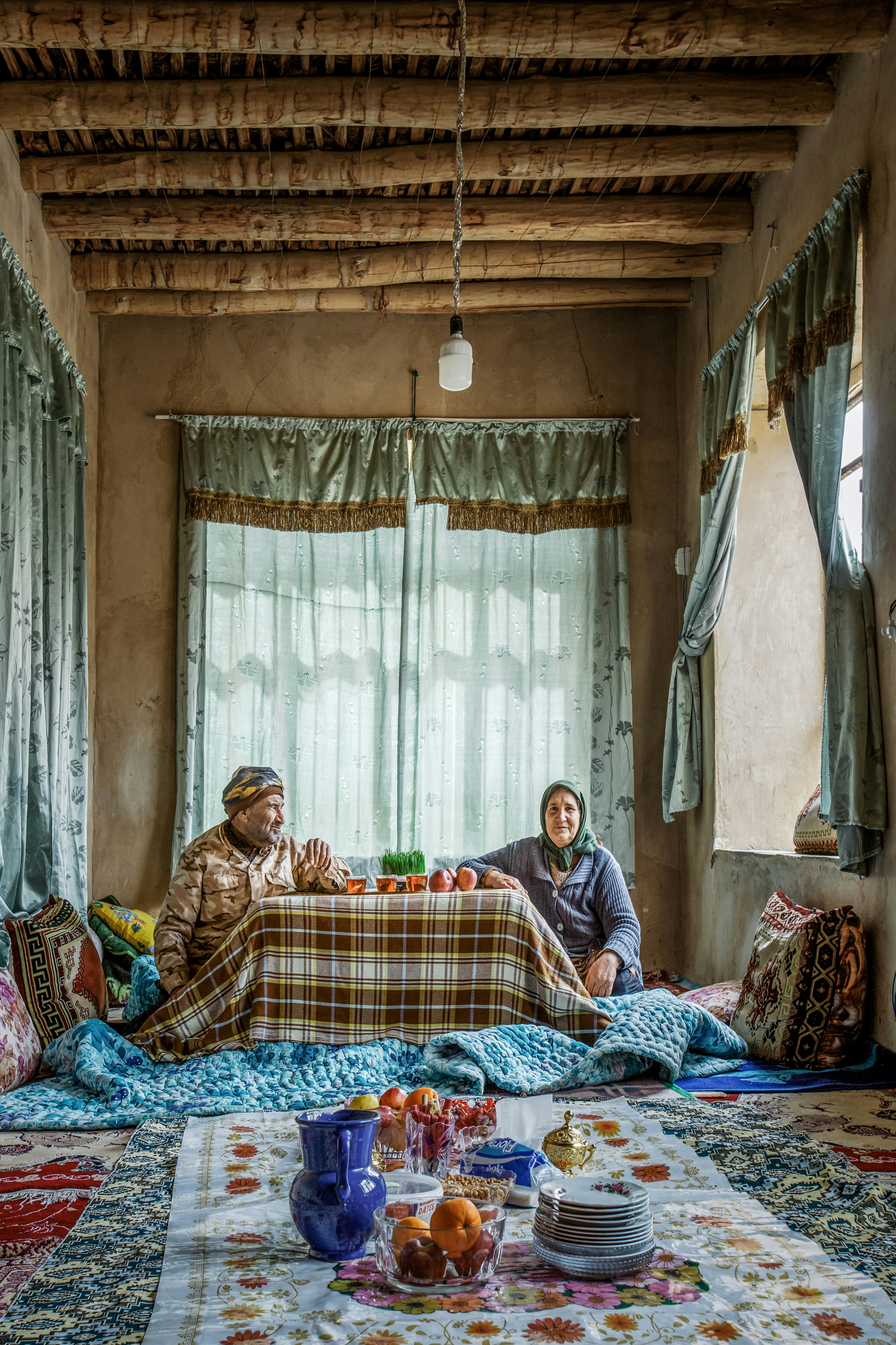 Shared Meal Under a Rustic Roof: A Quiet Moment Between Elderly Hosts