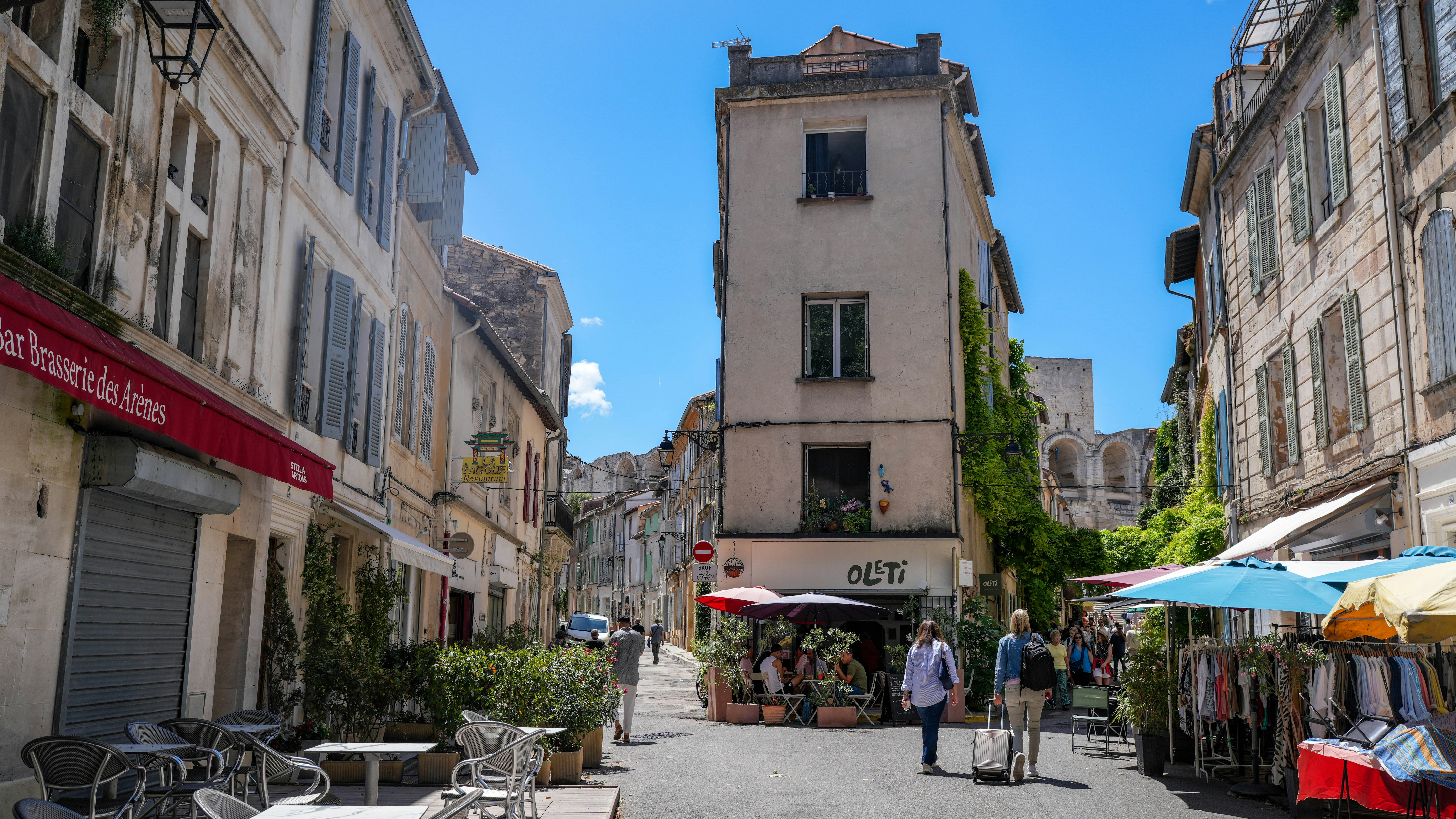 Sunlit Old Town Lane with Café Terrace and Carved Stone Facades