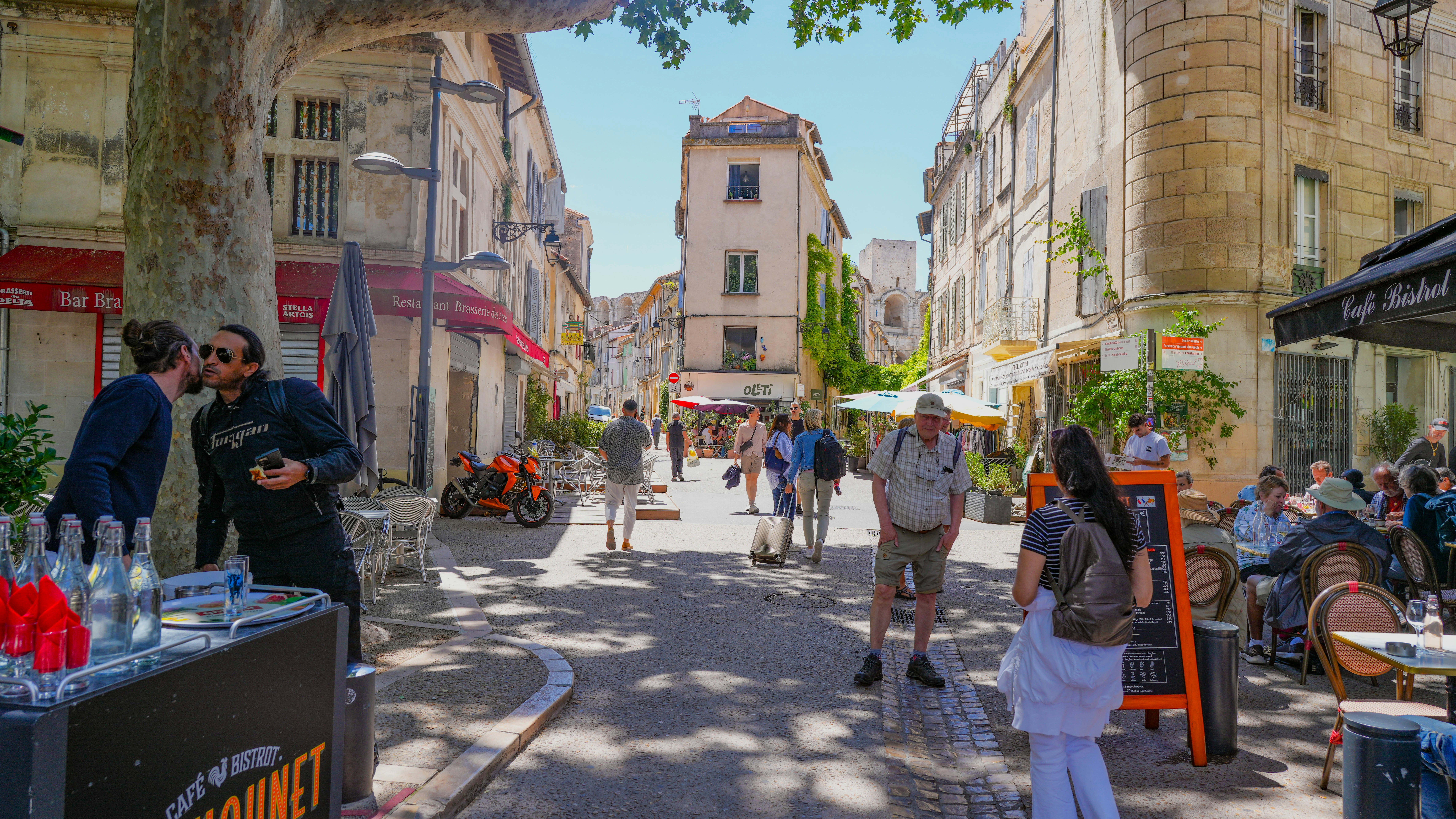 Sunlit Mediterranean Street: Café Life Under Shaded Arcades