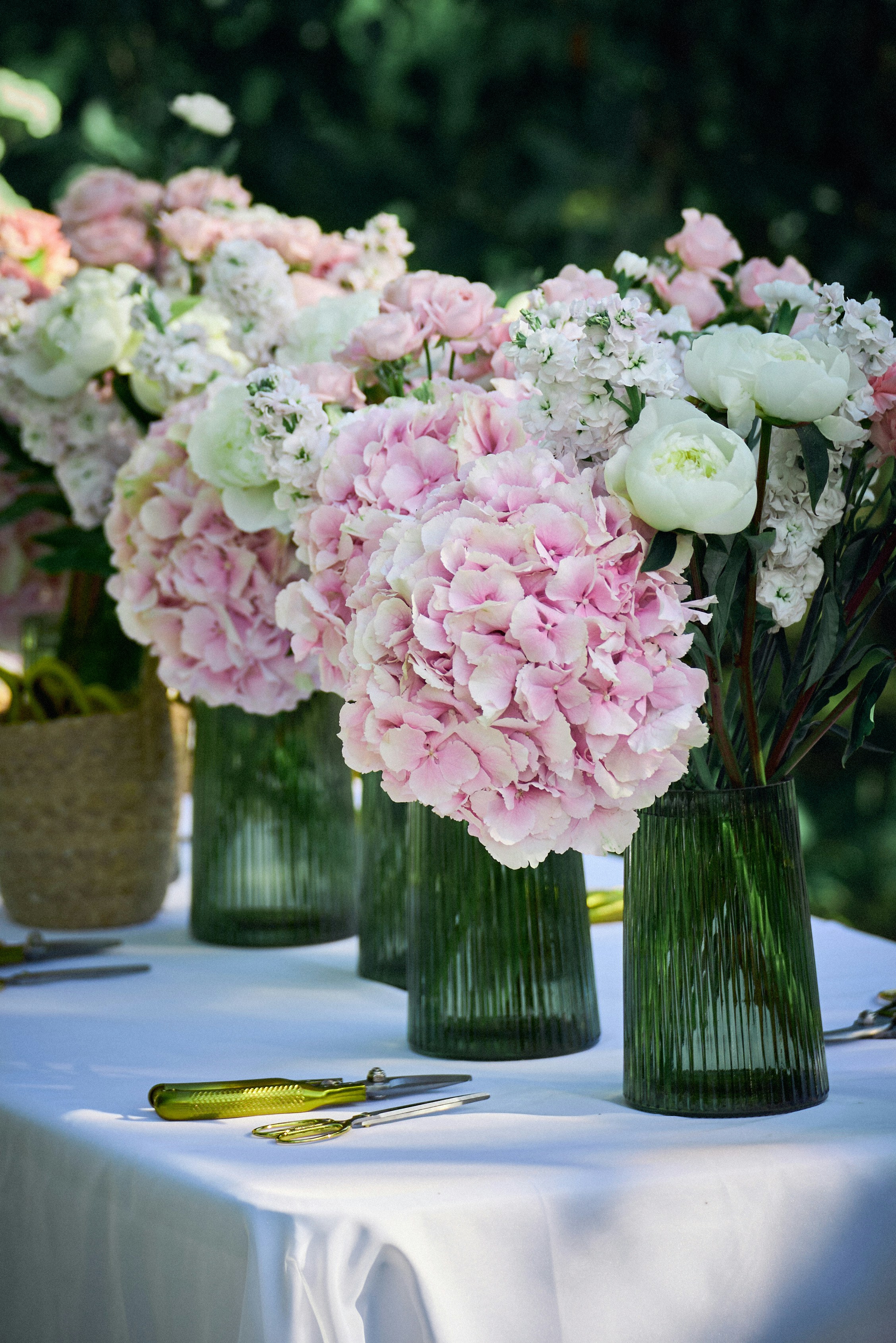 Pastel Hydrangea Cascade in Green Glass Vases on a White Table