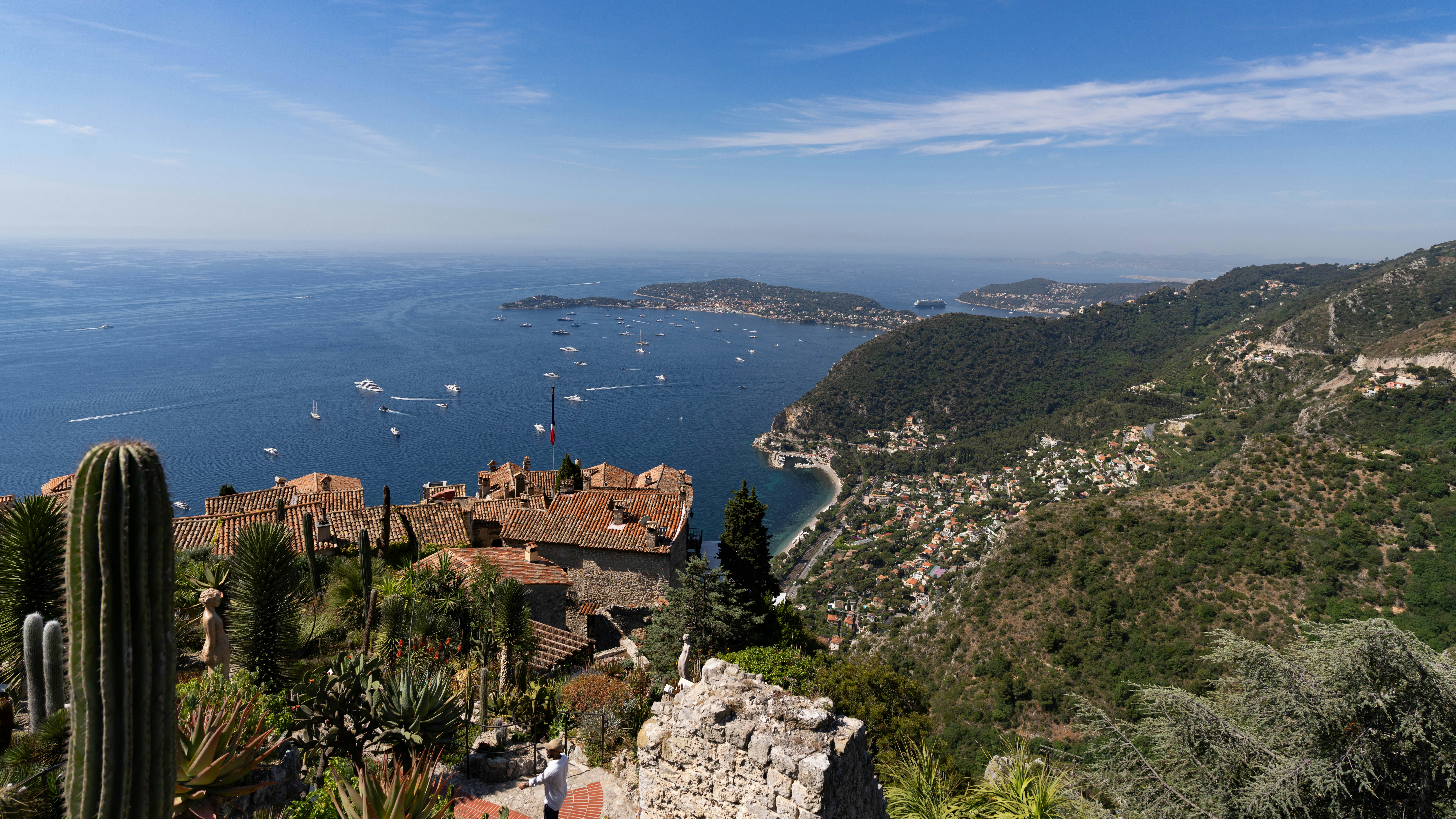 Terraced village on the cliff edge overlooking a sapphire cove