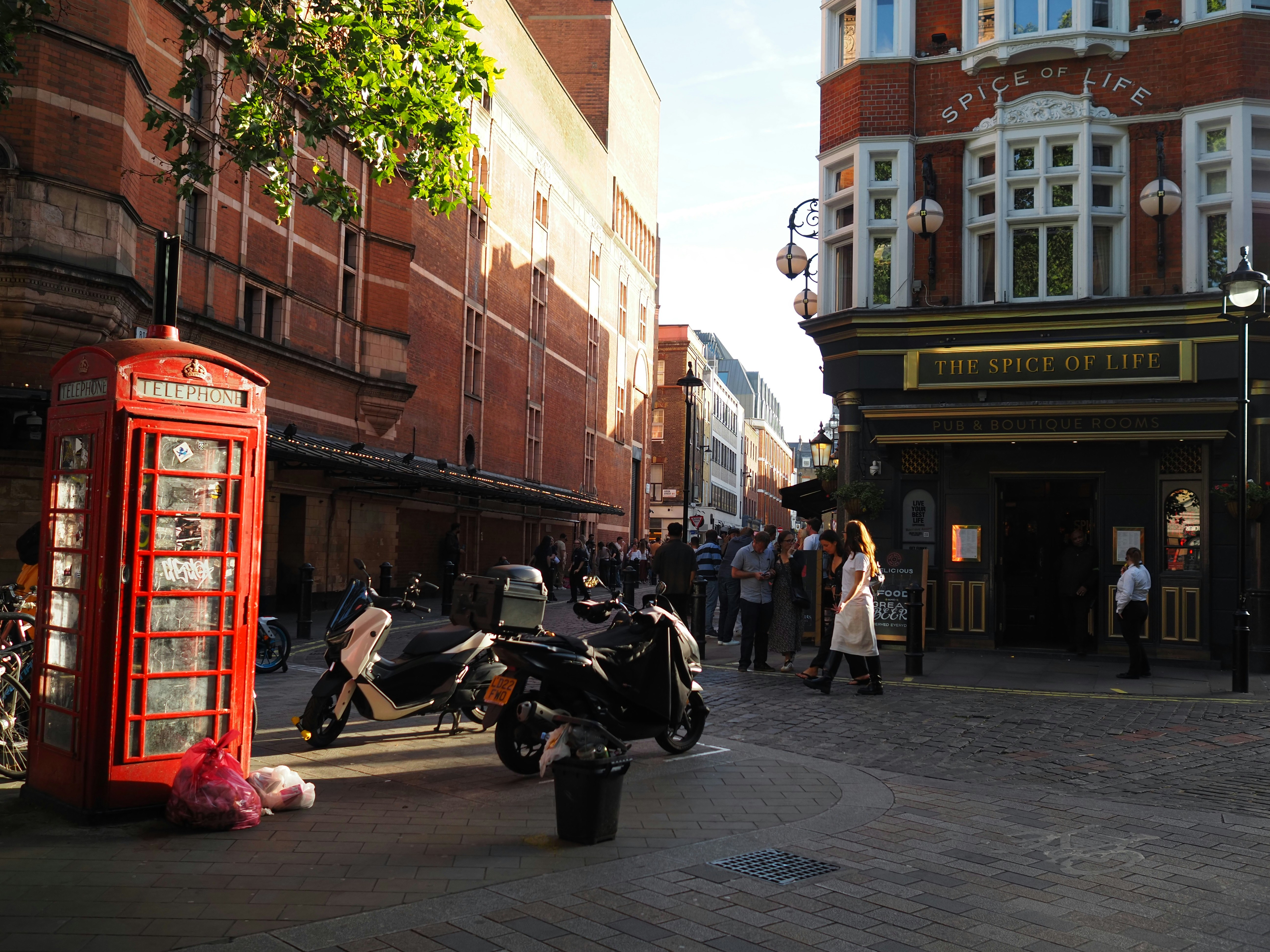 Red Phone Box and Evening Pub Glow on a Bustling London Street