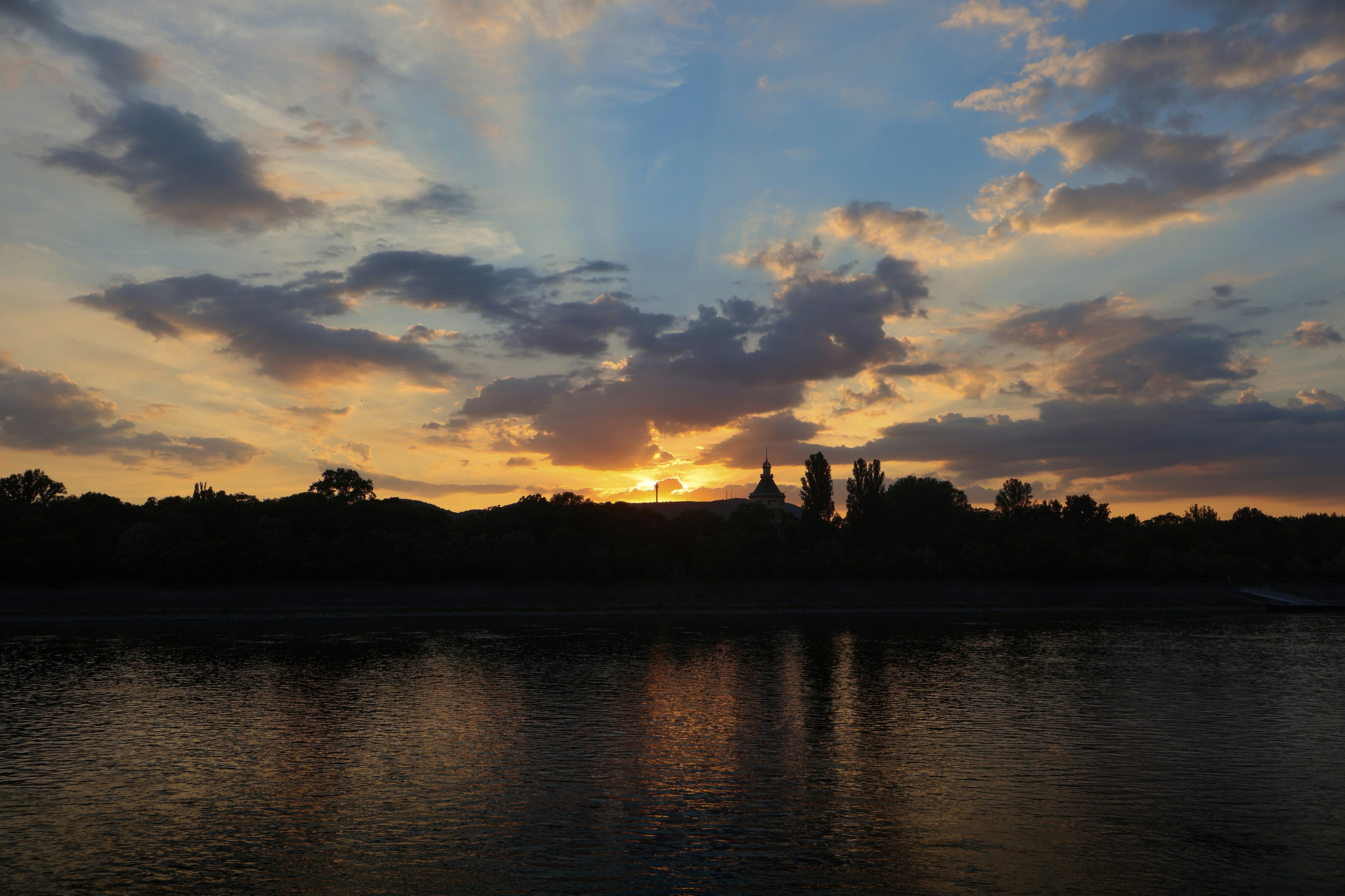 Dawn’s Quiet Burst: Horizon Fire Over a Serene River