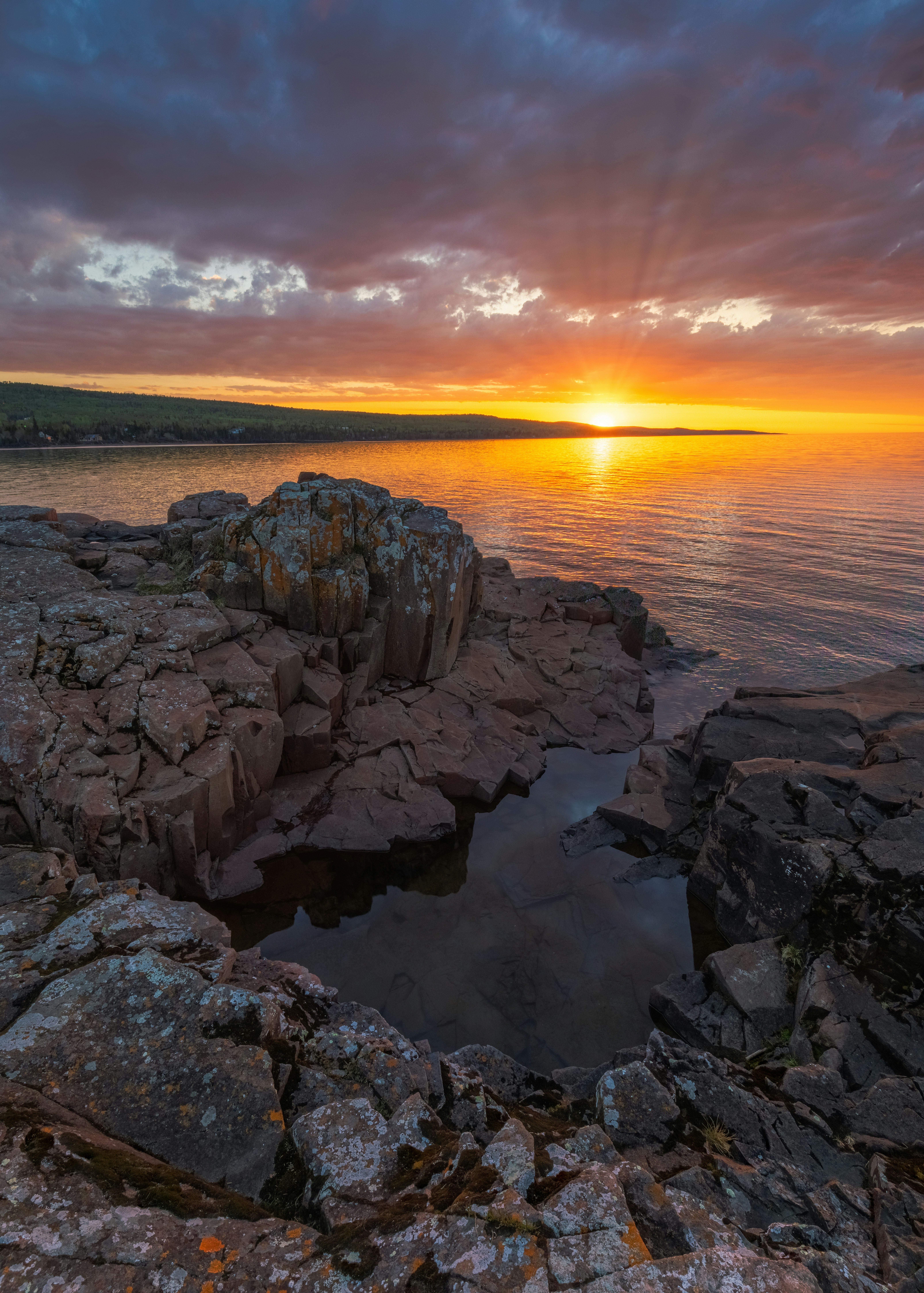 Rugged shoreline at golden hour with sunlit water and dramatic rocks