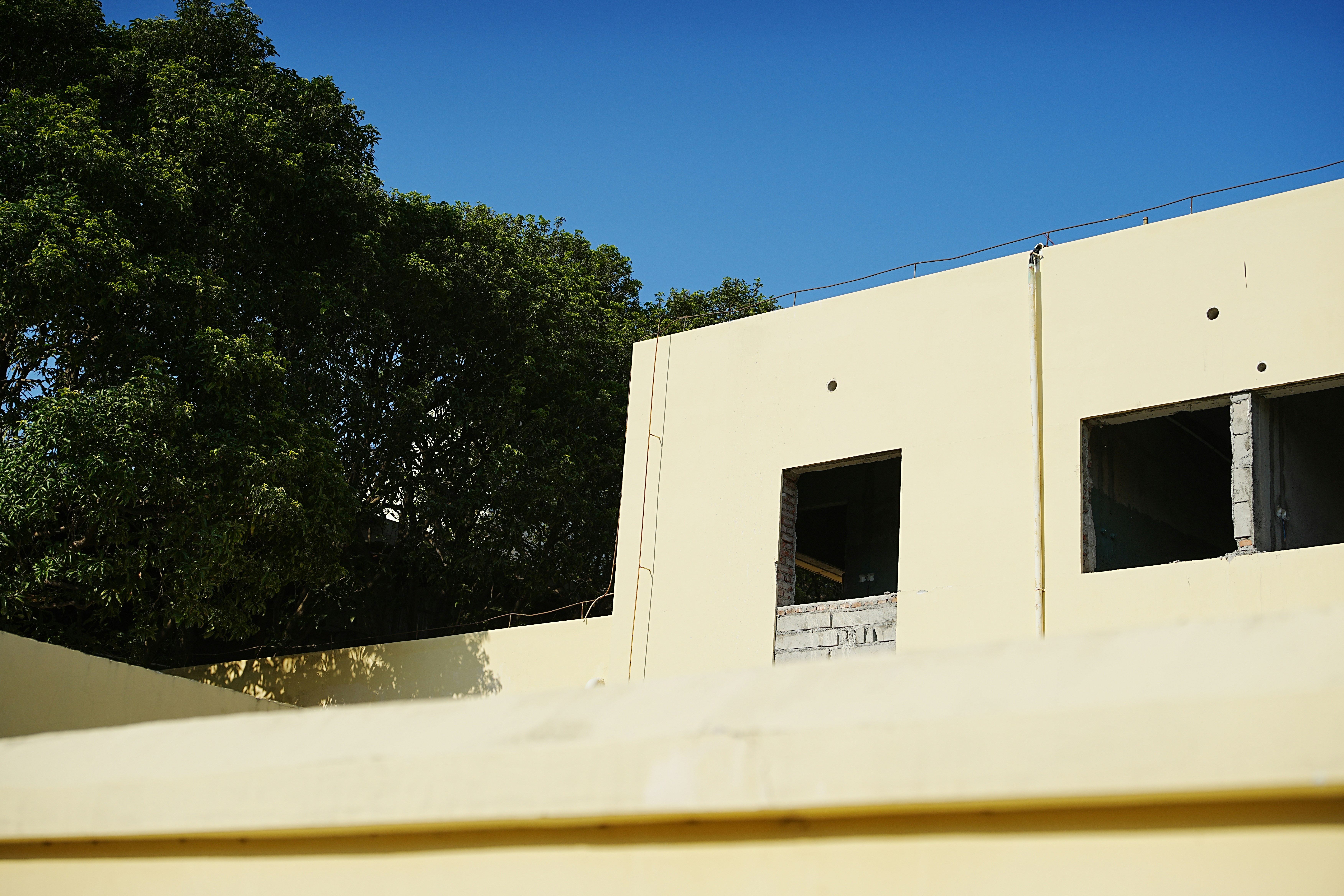 Sunlit Yellow Facade Under a Clear Blue Sky