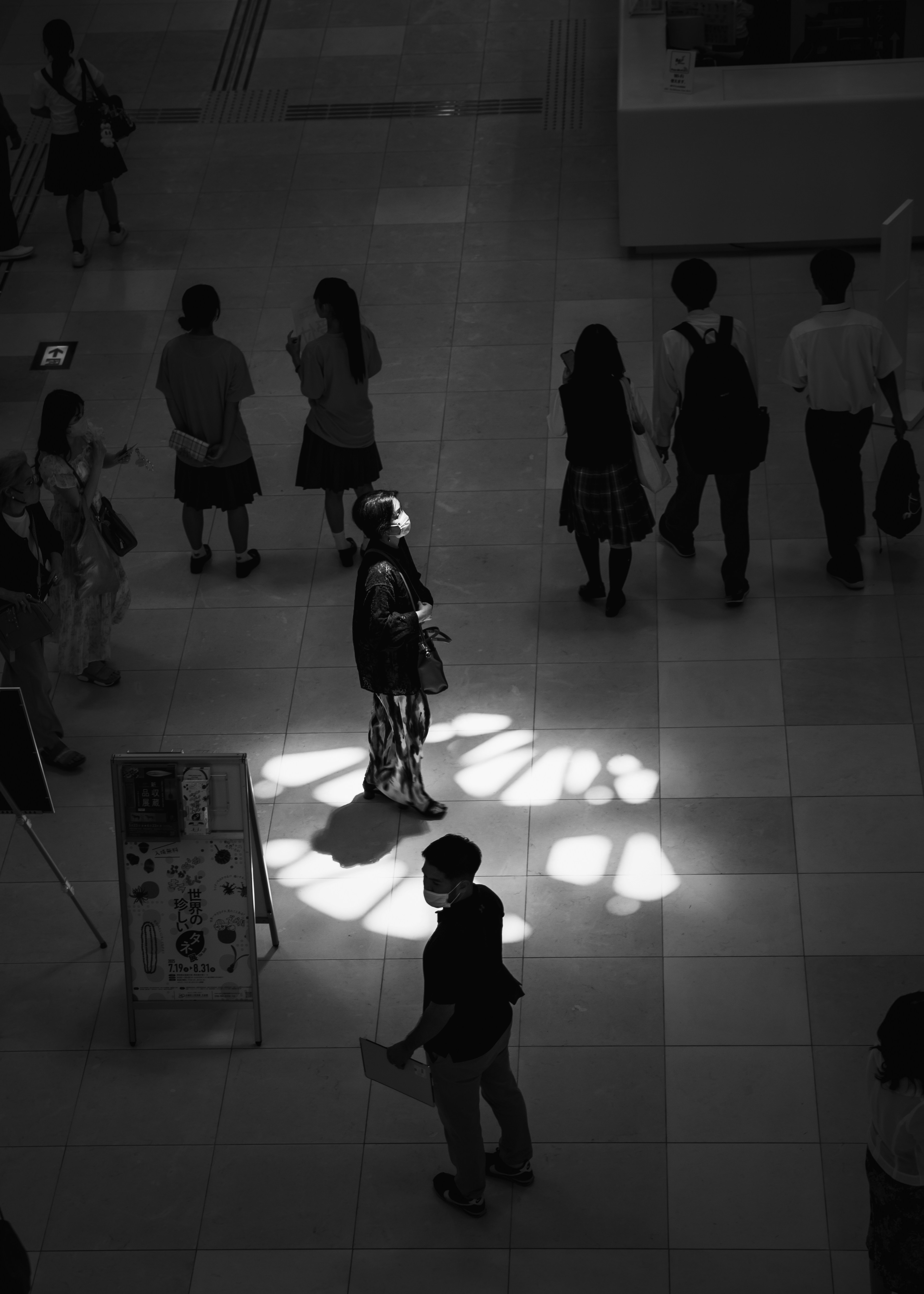 Spotlit Figure in a Busy Monochrome Atrium