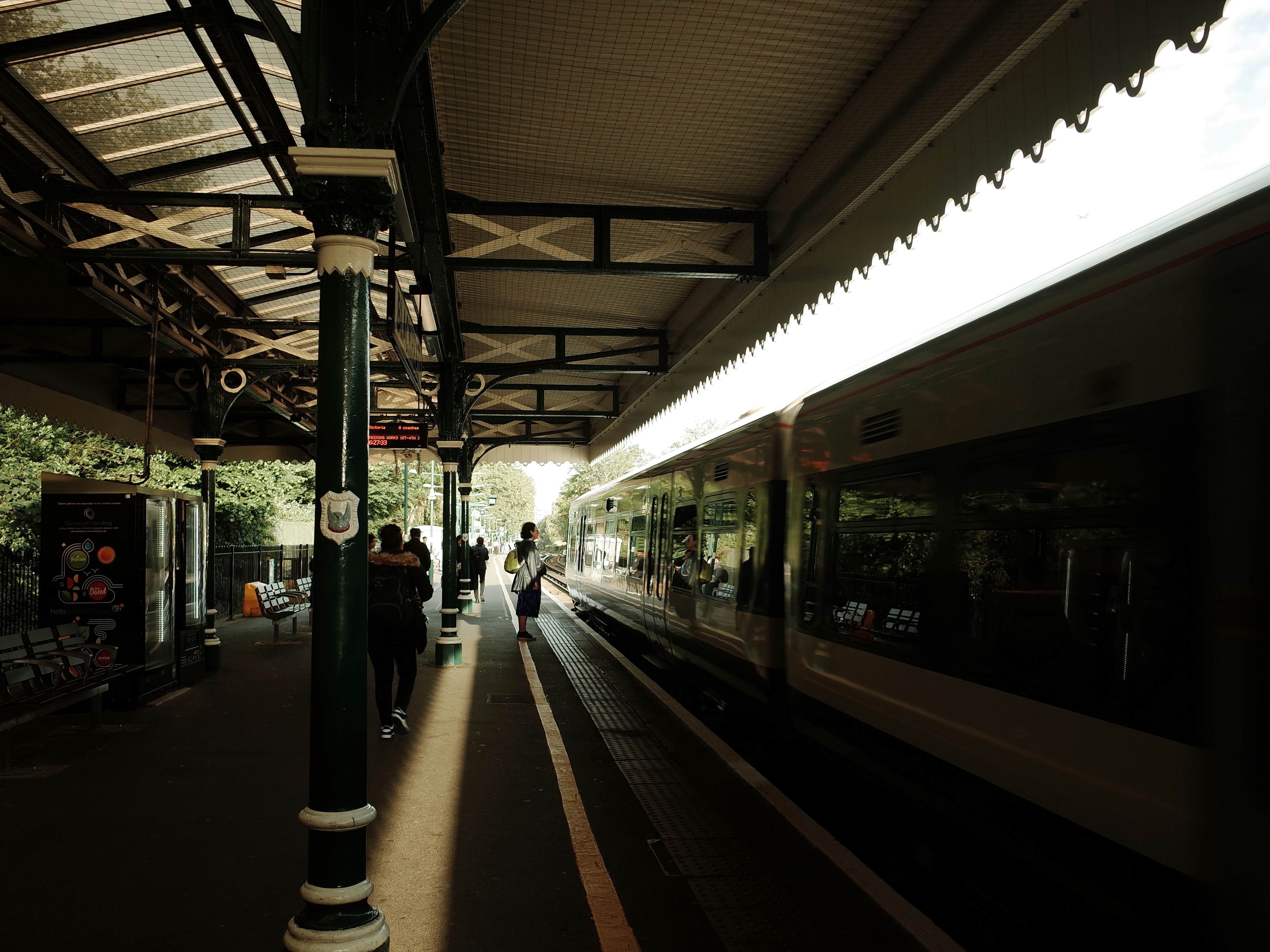 Platform Glow: Train, Passengers, and Dappled Light at a Quiet Station