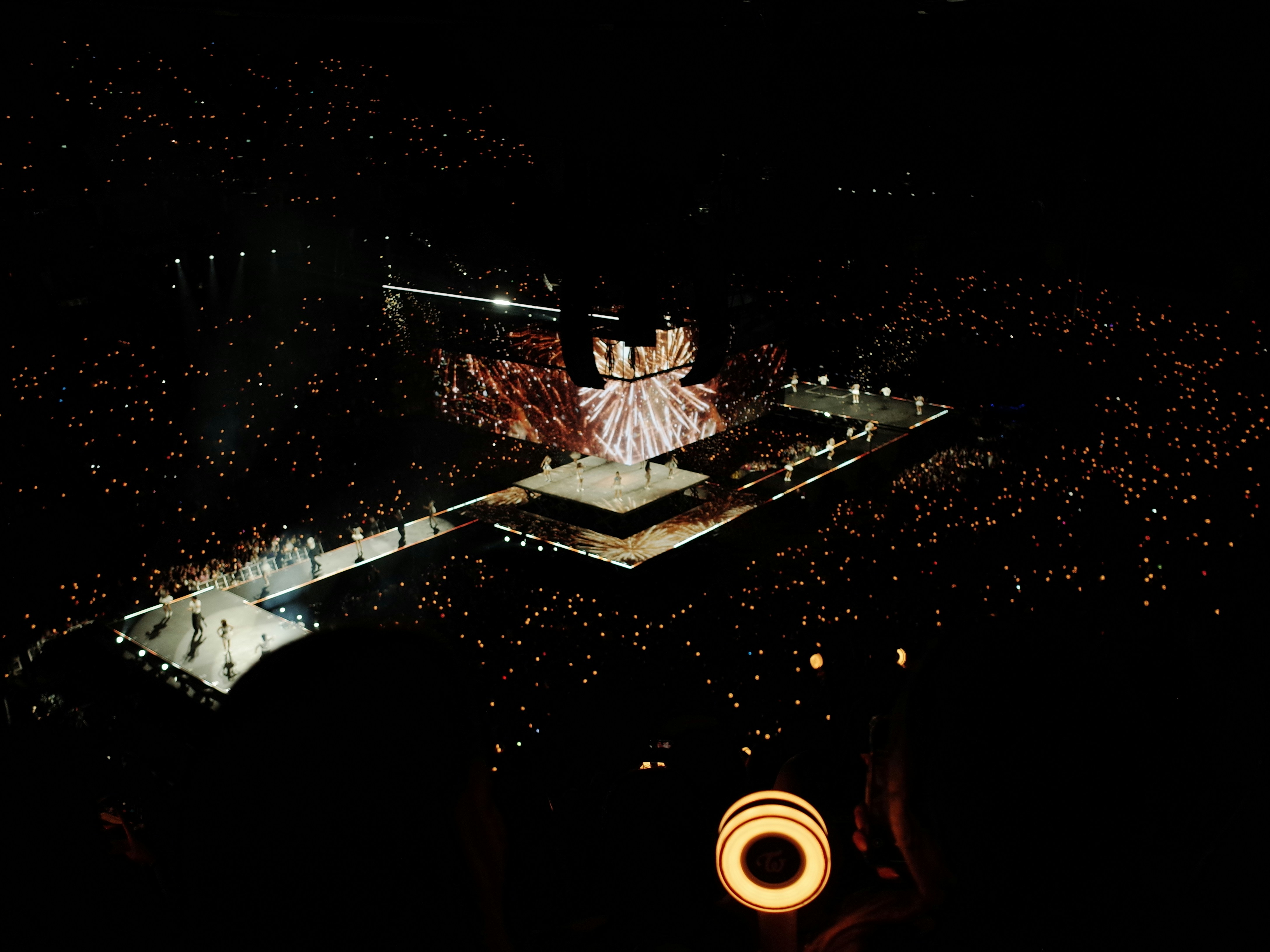 A Neon-lit Crescent: Crowd-swept Stage at Night