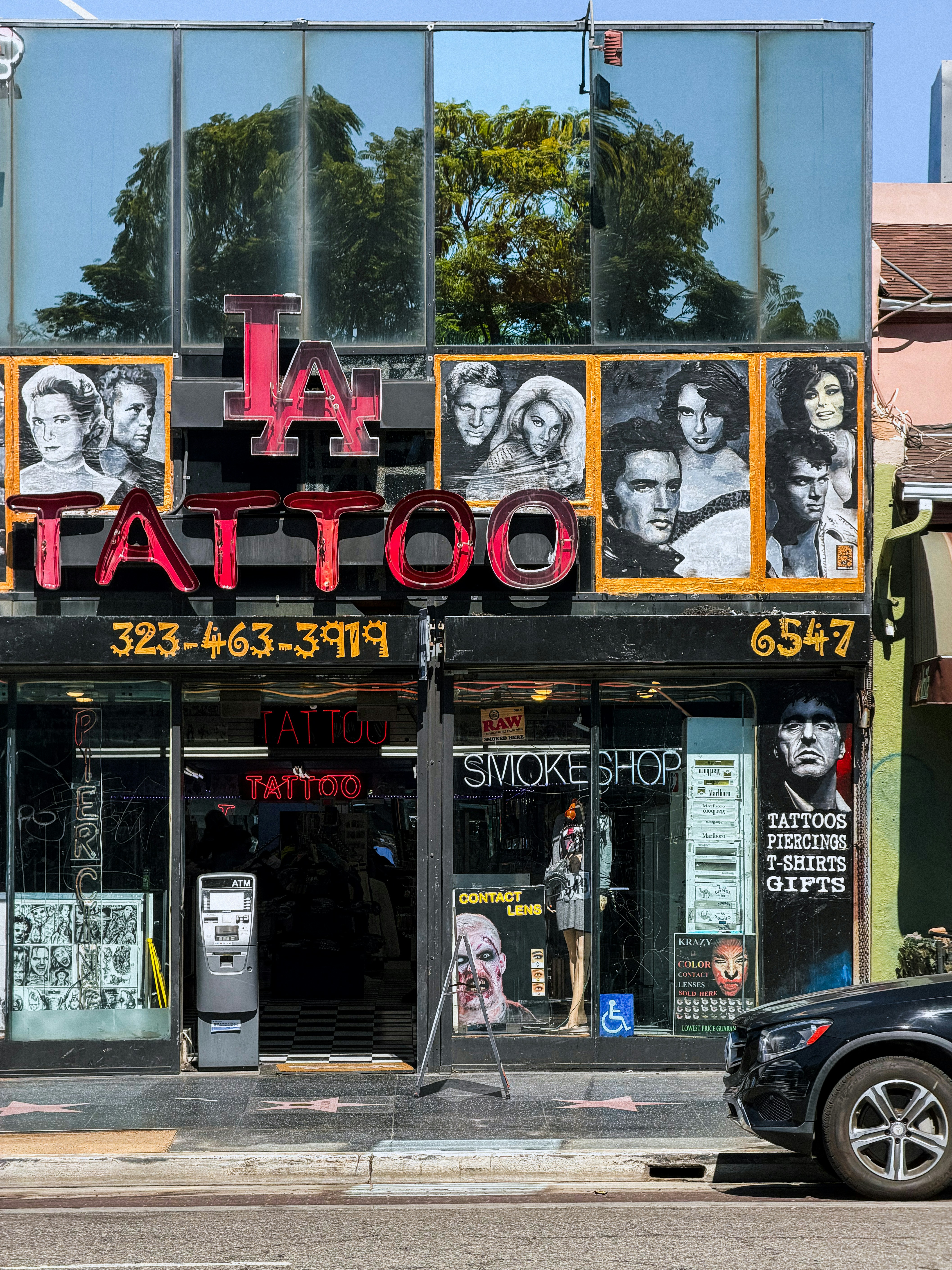 LA Tattoo Parlor Neon Sign Under Glass Frontage