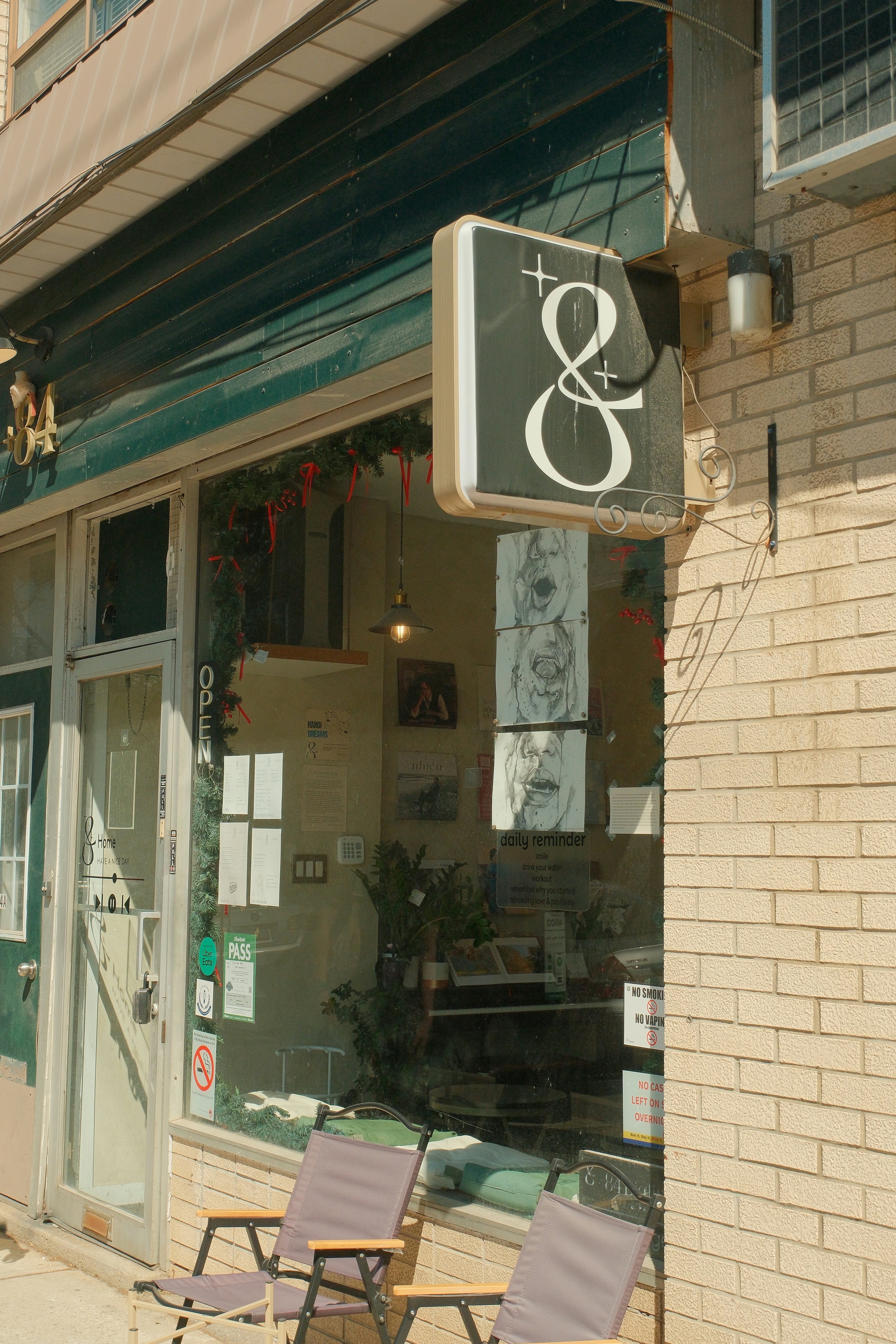 Shopfront Signage and Street Seating Beyond a Glass-Faced Cafe