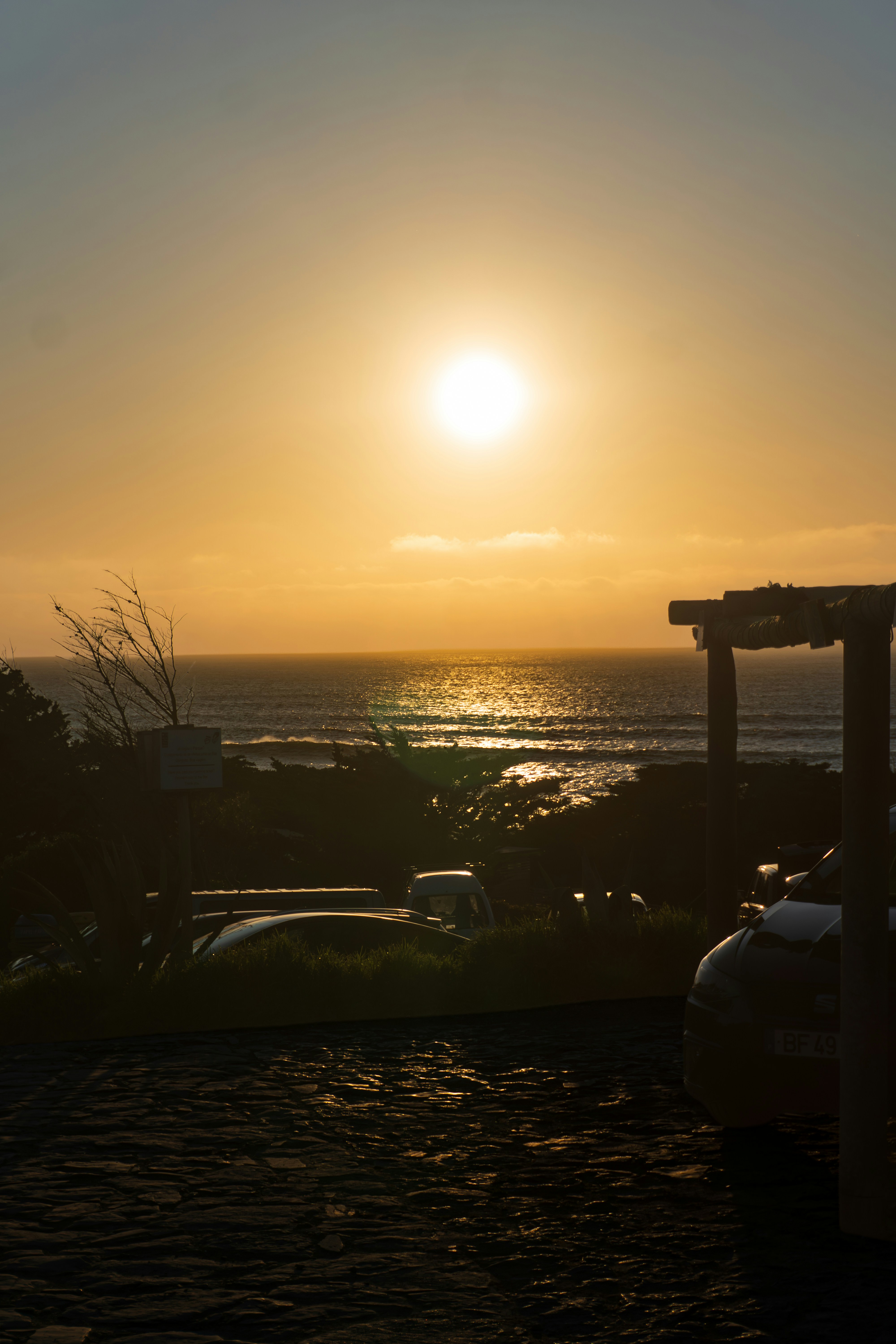 Golden Hour Overlook: Coastal Sea and Silhouetted Parking