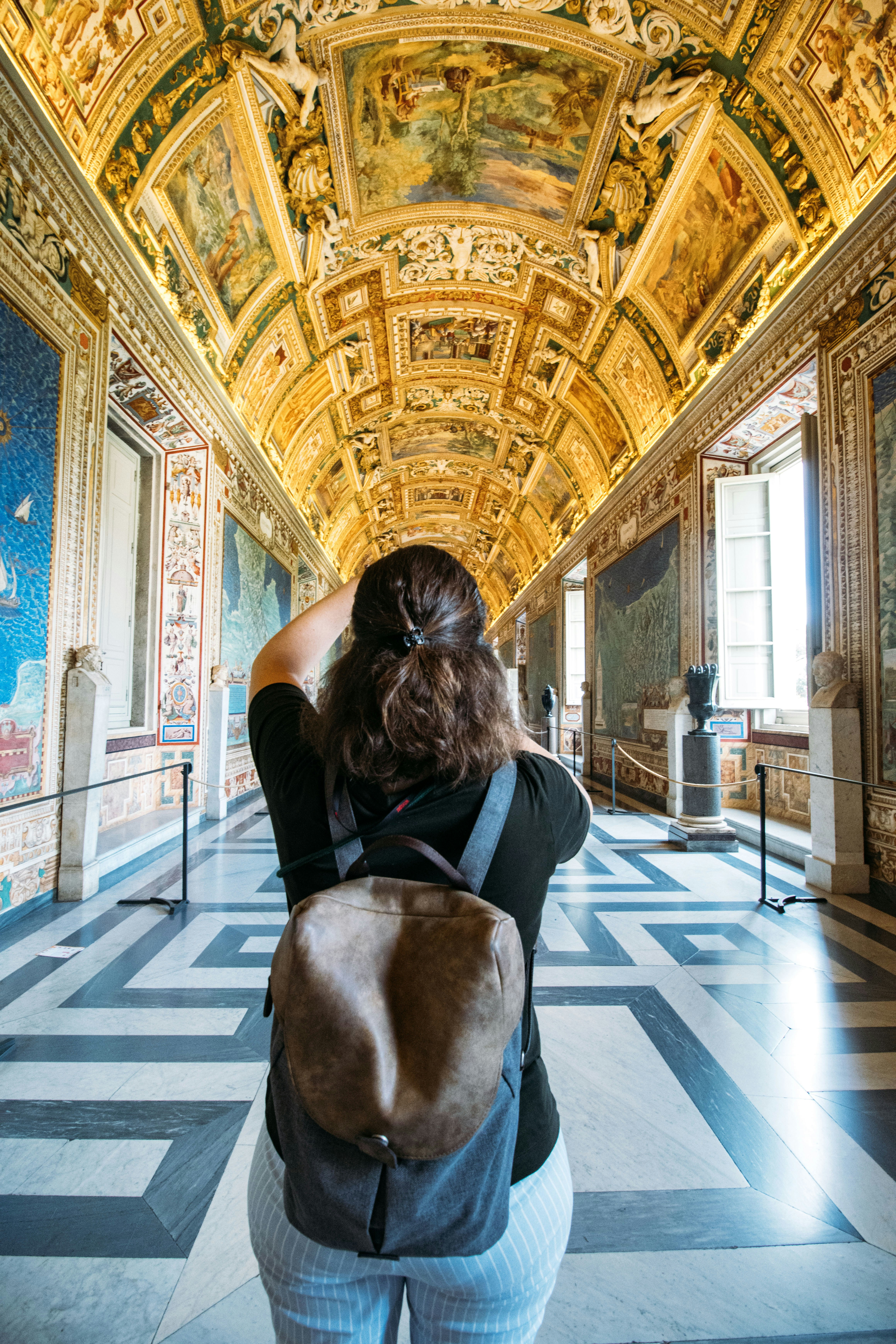 Backpack in a Golden Gallery: A Visitor Immersed in Baroque Grandeur