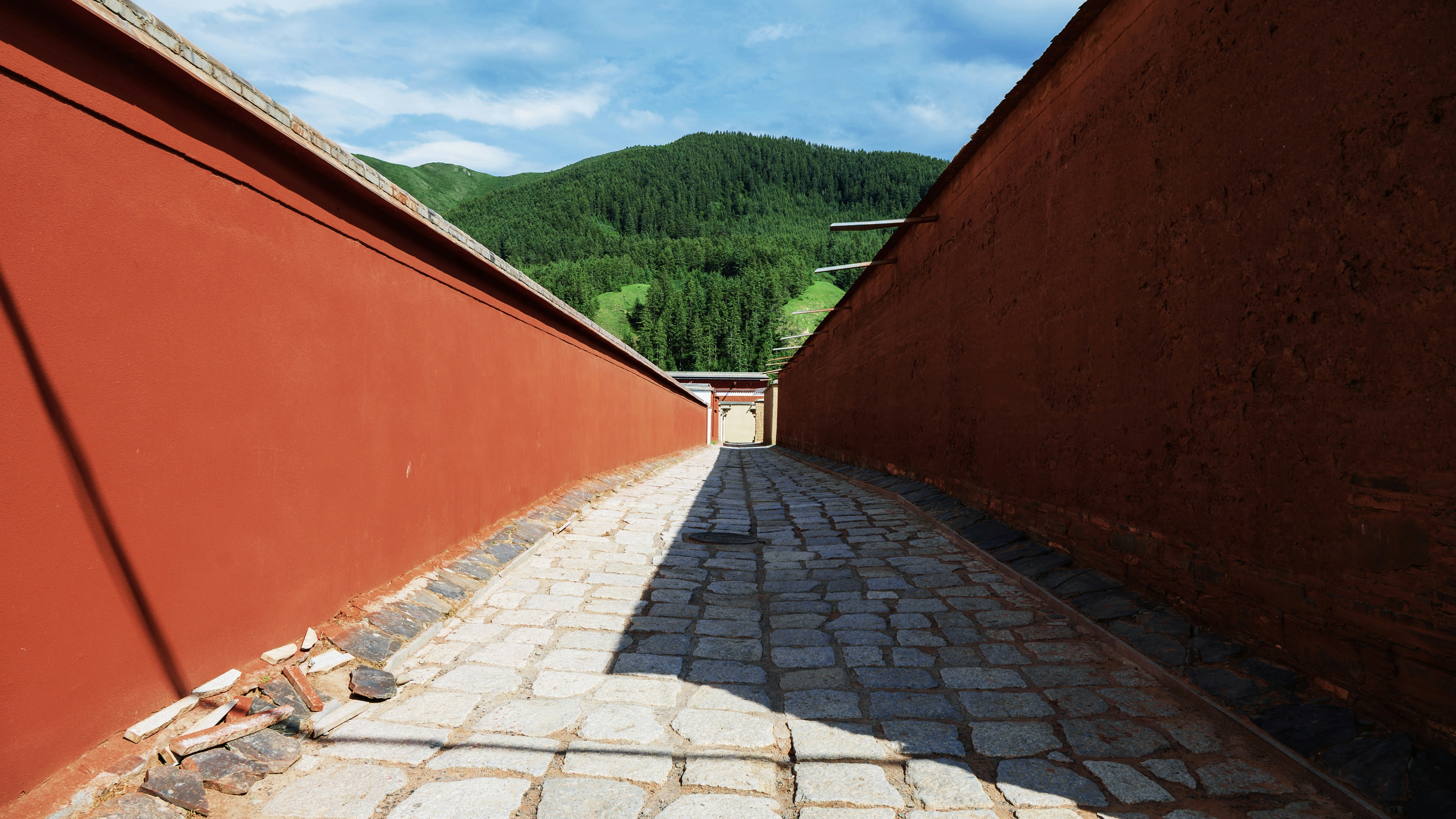 Red Wall Corridor Toward a Mountain Gate