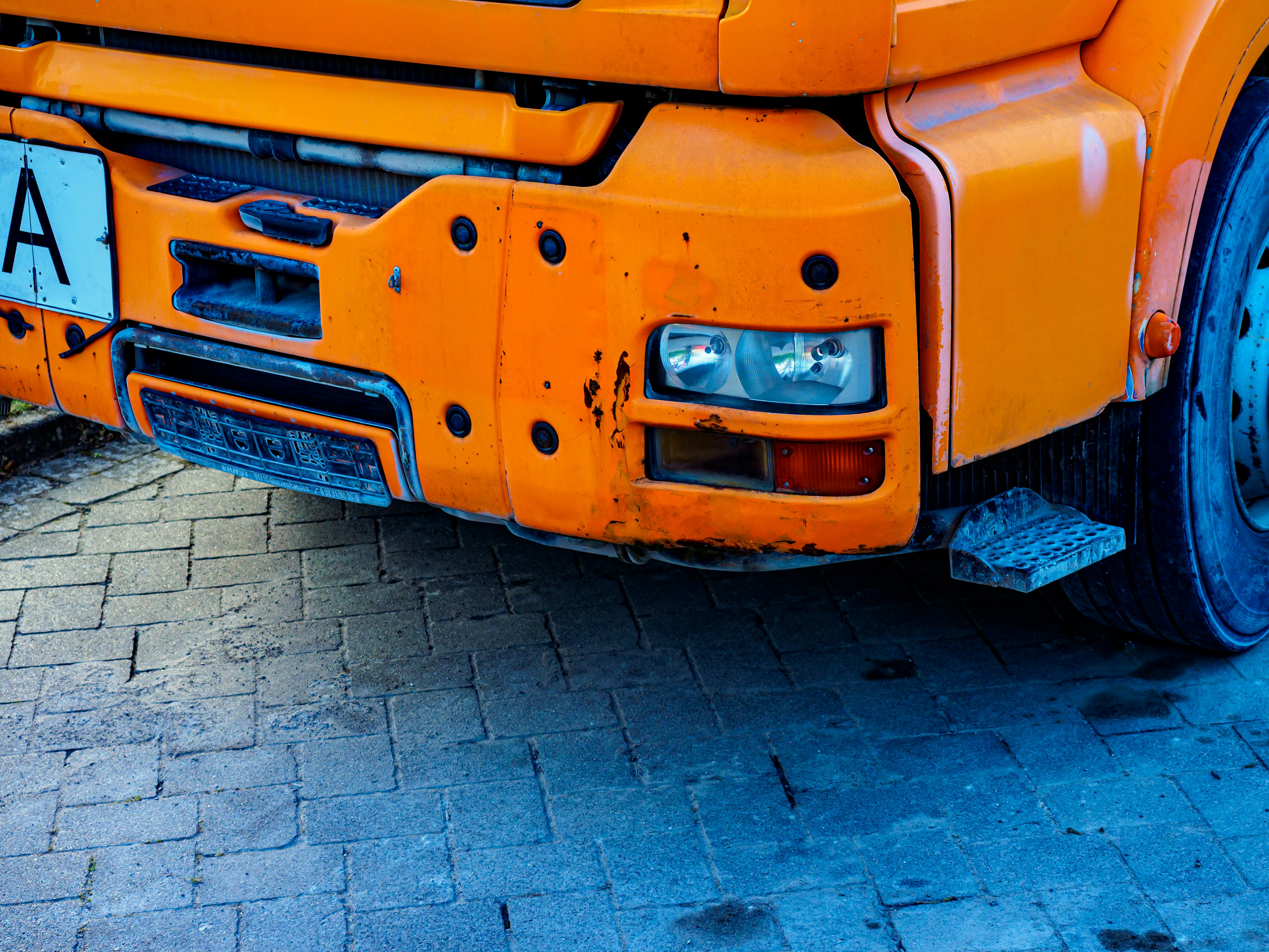 Orange front-end detail: a rugged, weathered truck face