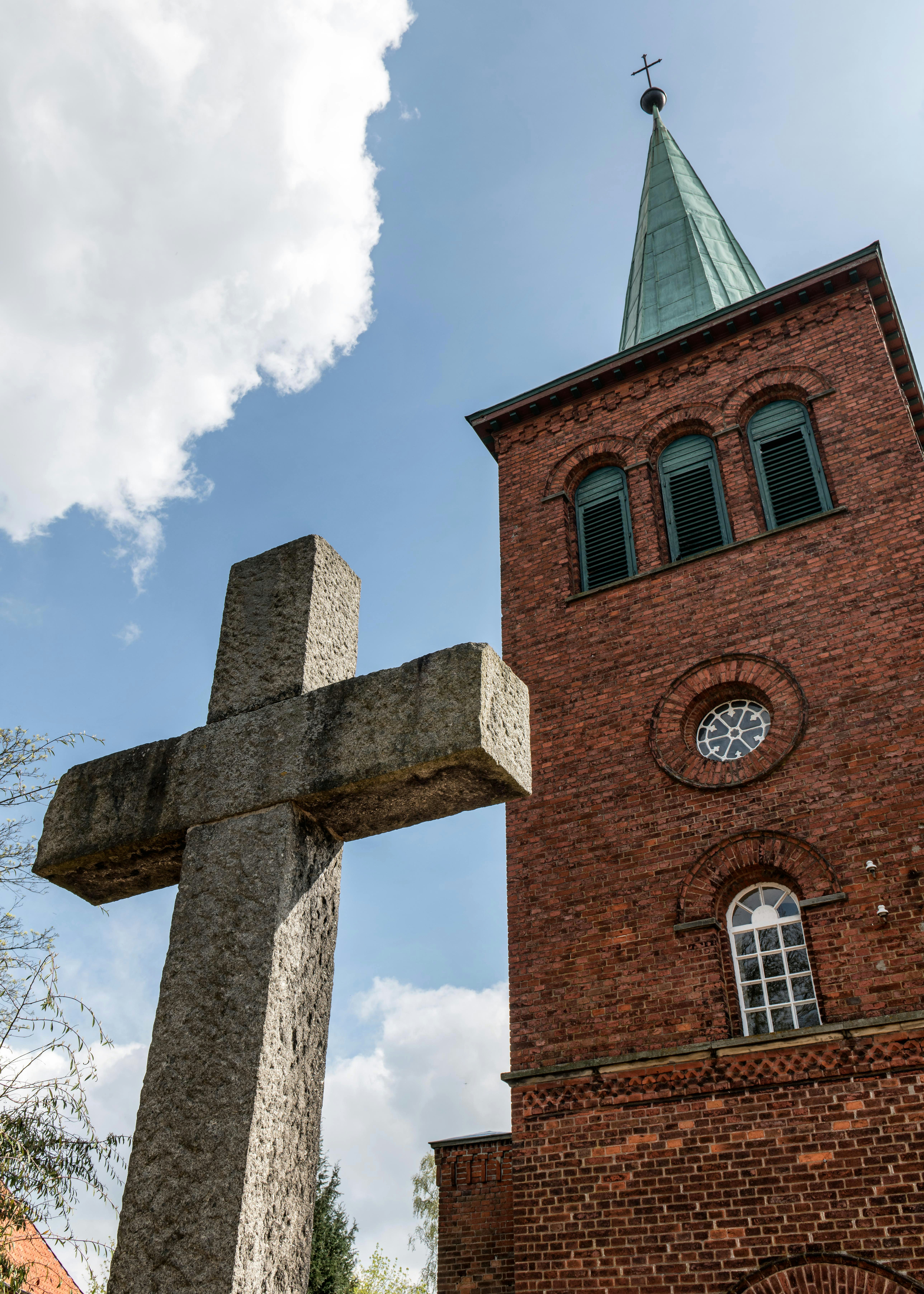 Stone Cross and Church Tower: A Quiet Moment Beneath Blue Skies