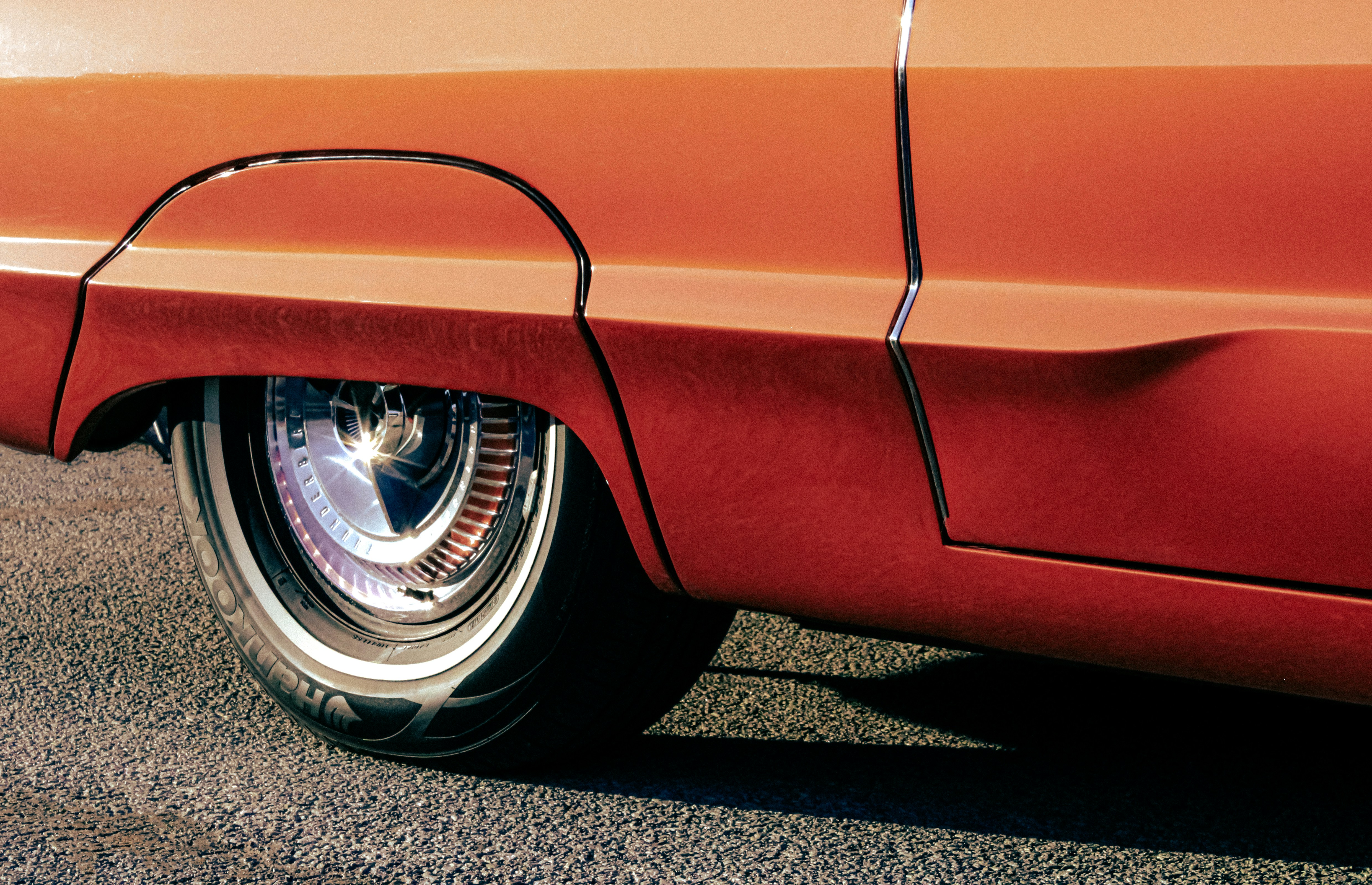 Red Wing, Quiet Dynamics: A Classic Car's Curves in Sunlit Asphalt