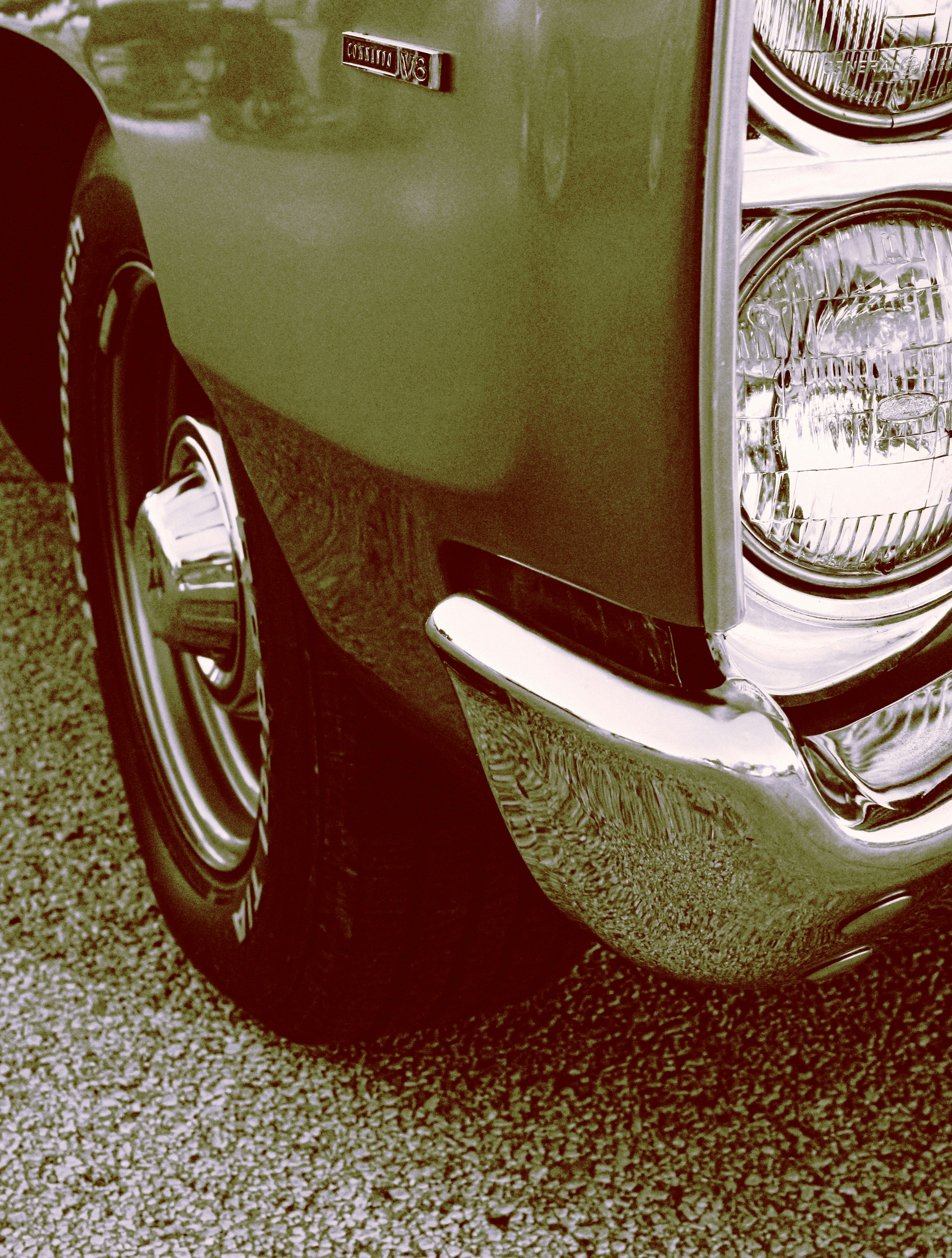Chrome Bumper and Headlamp Closeup on Vintage Green Vehicle