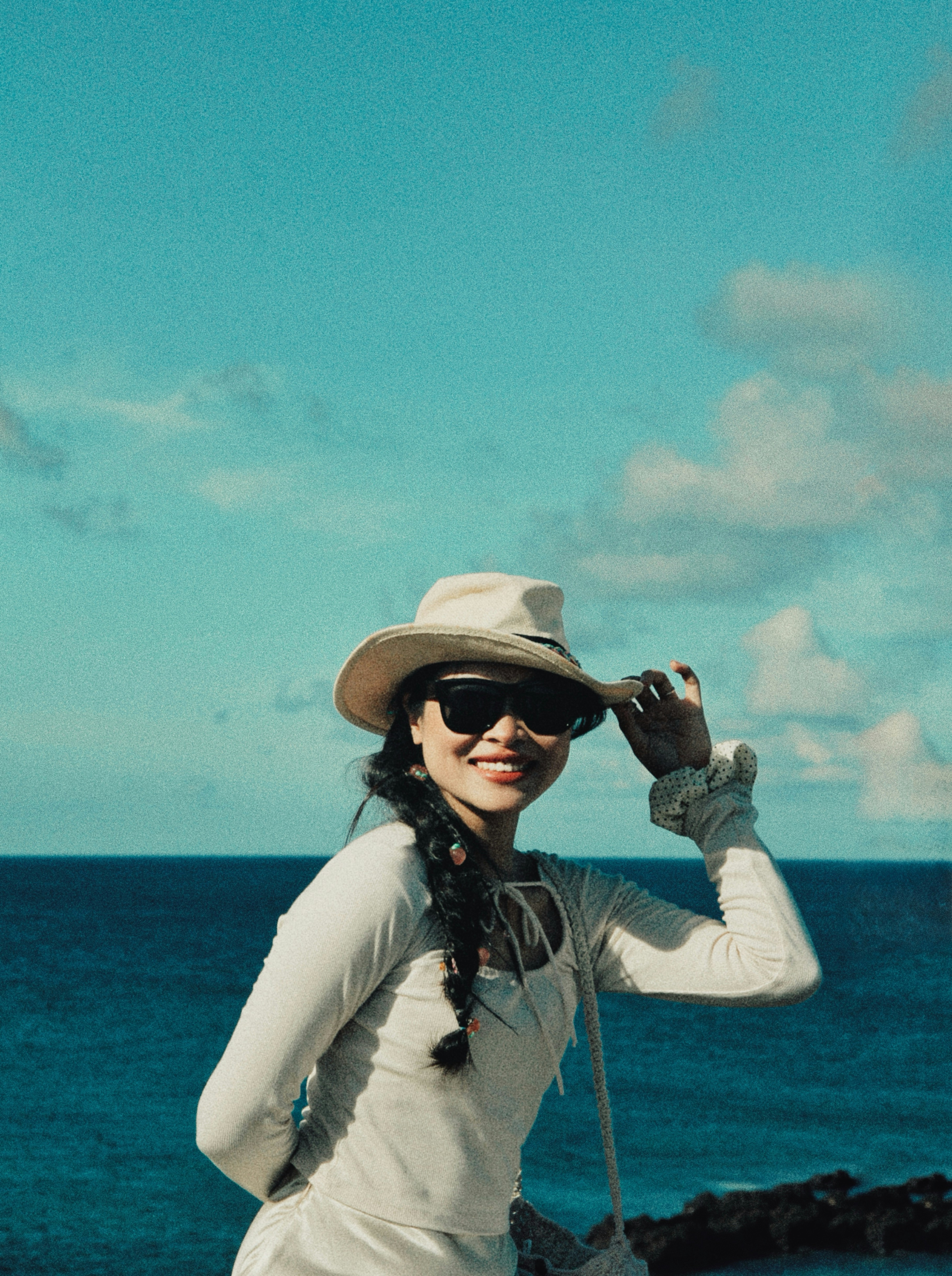Sunlit Seaside Smile: A Wide-Eyed Moment in White Linen