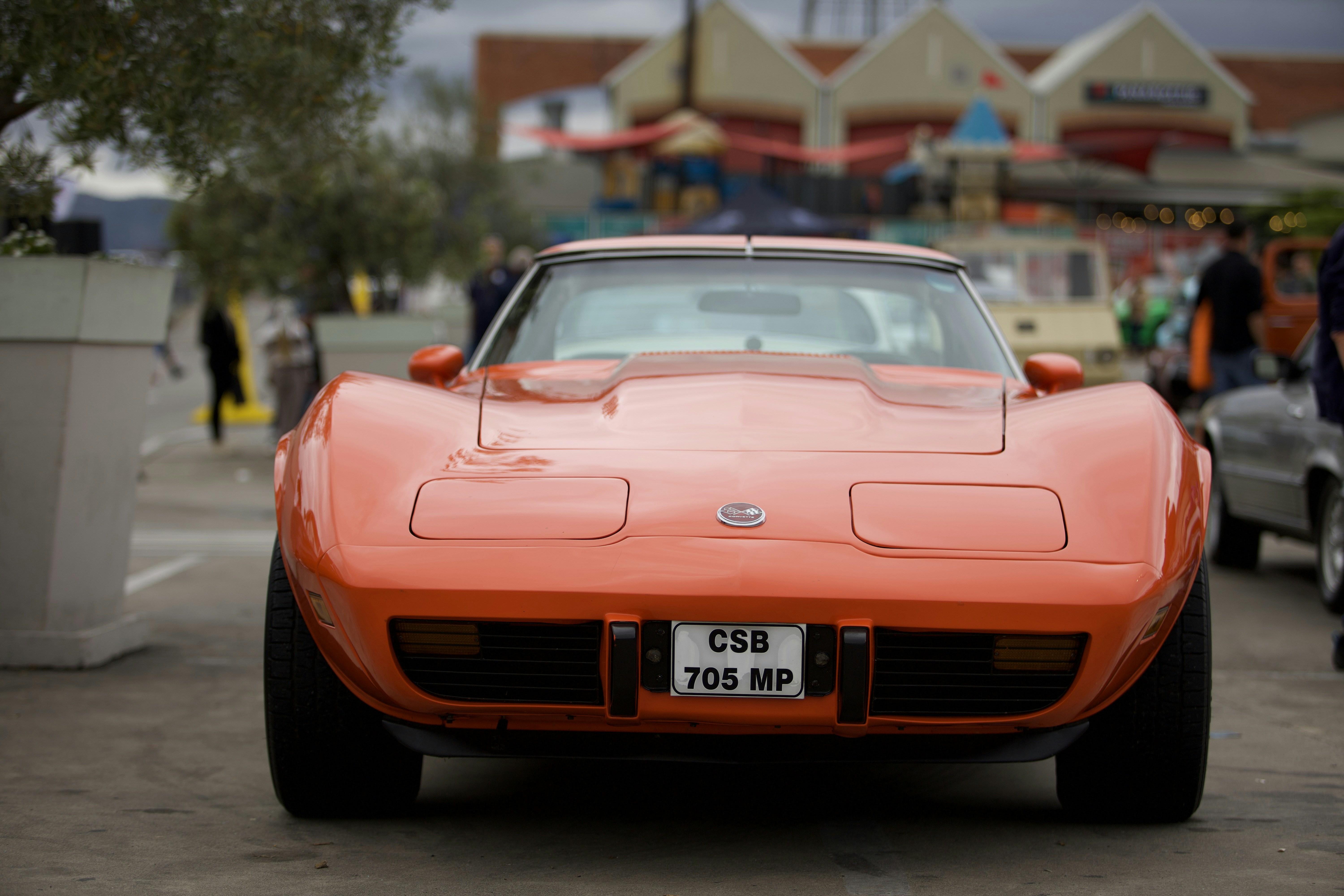 Chrome-Red Icon: A Classic Corvette Anchored in a Busy Street Scene