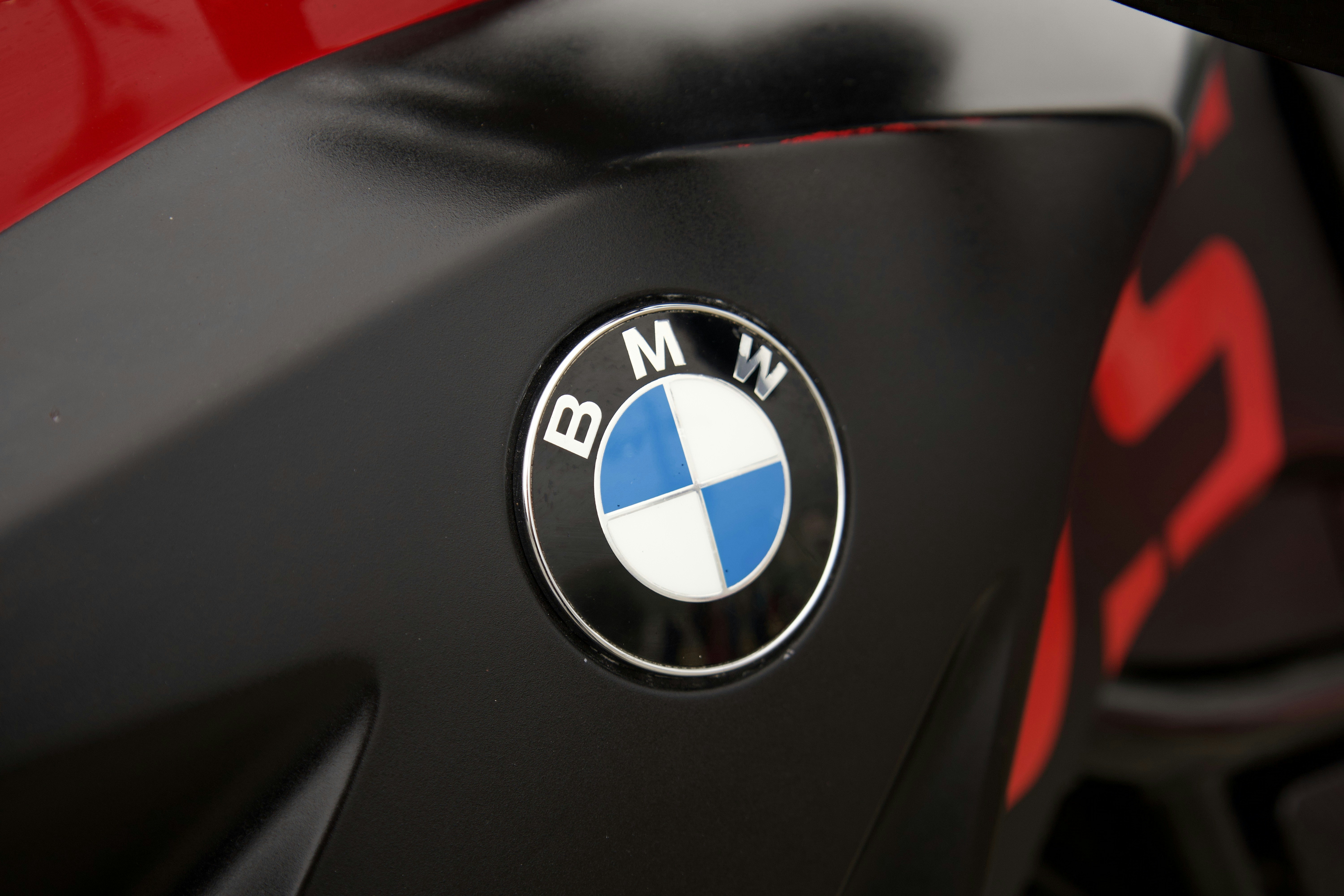 BMW Emblem on Matte Black Bodywork: Subtle Red Accent in the Frame