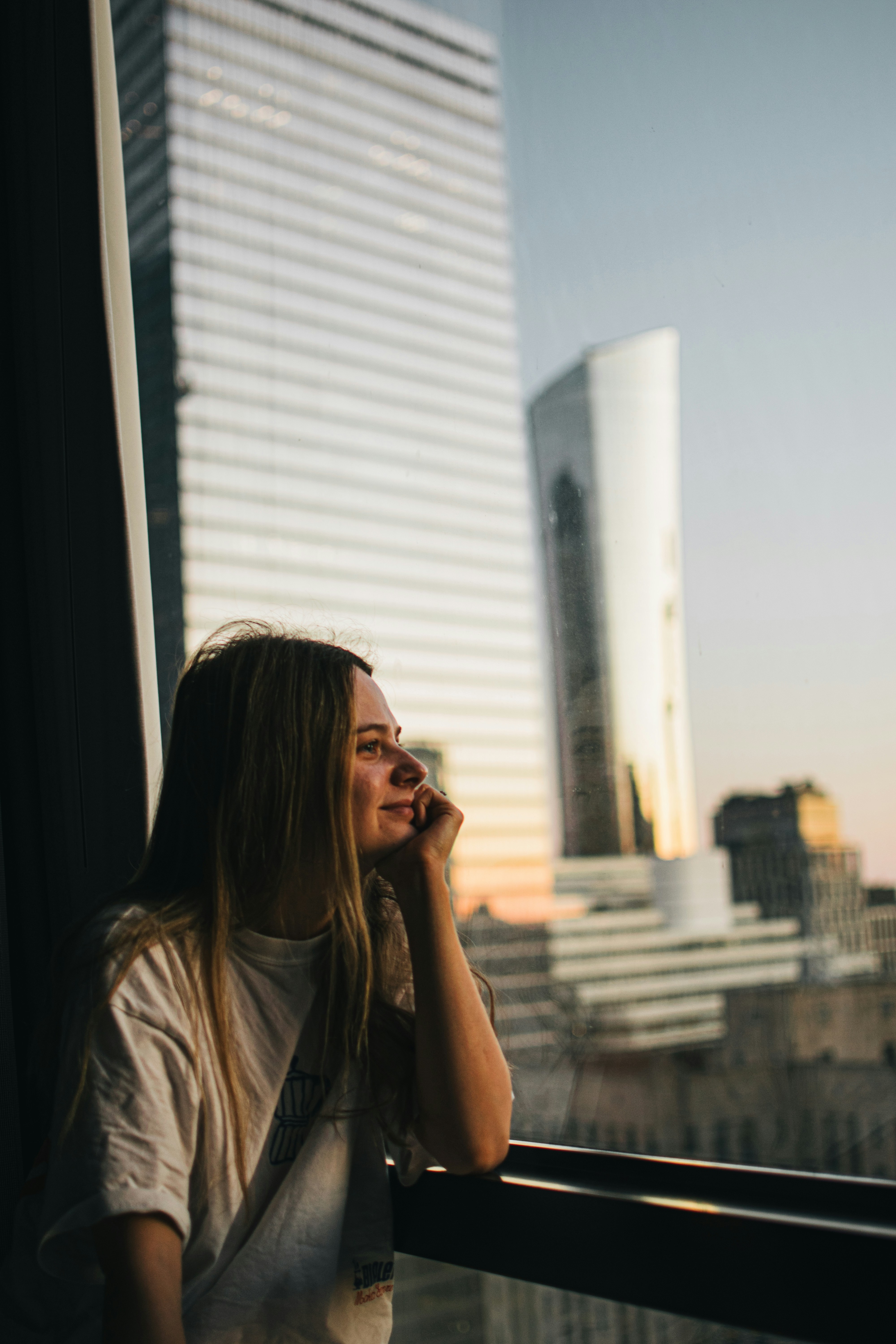 Quiet Contemplation by the Window with City Towers