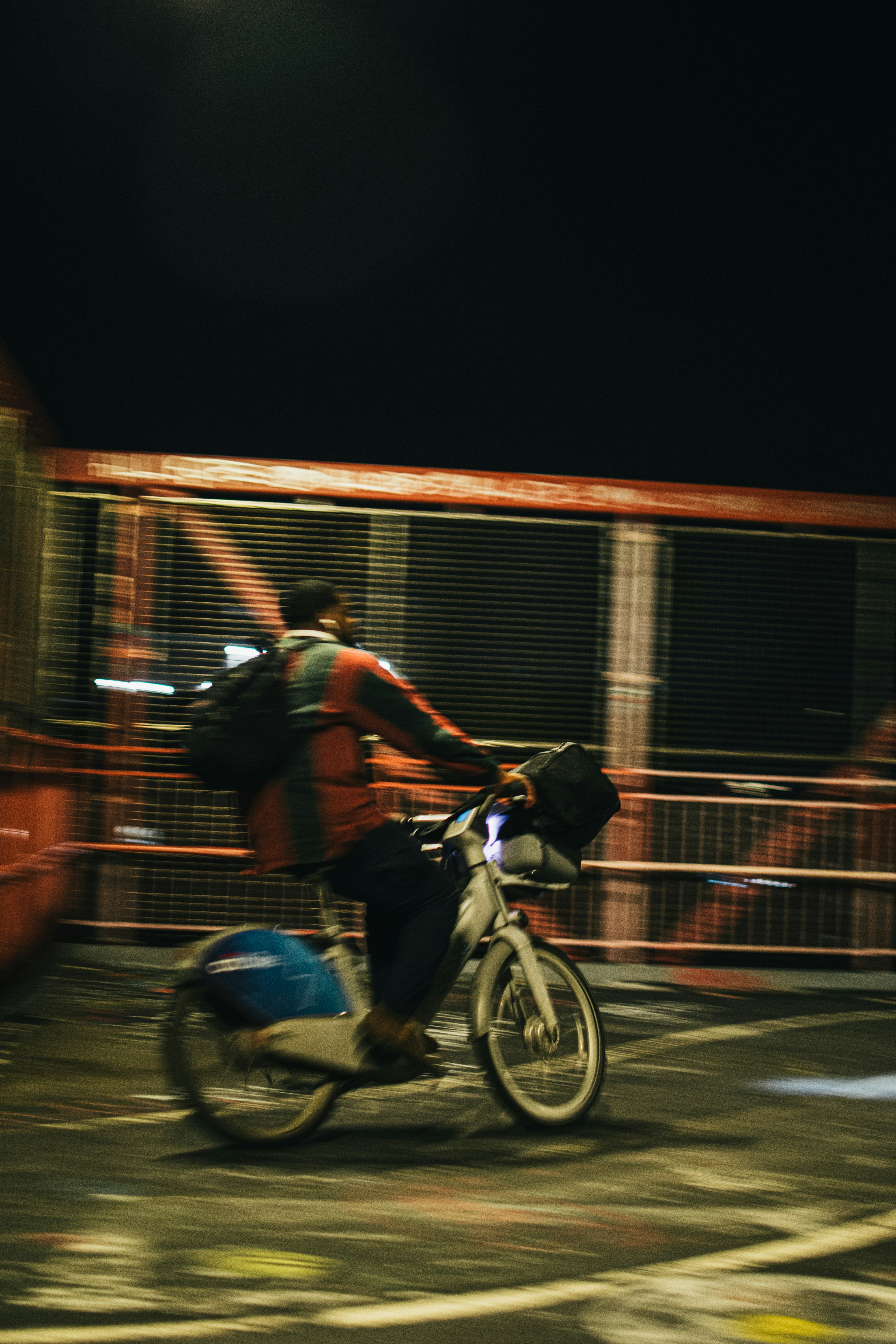 Night Ride: A Rider Surges Through the Fence-Lit Street