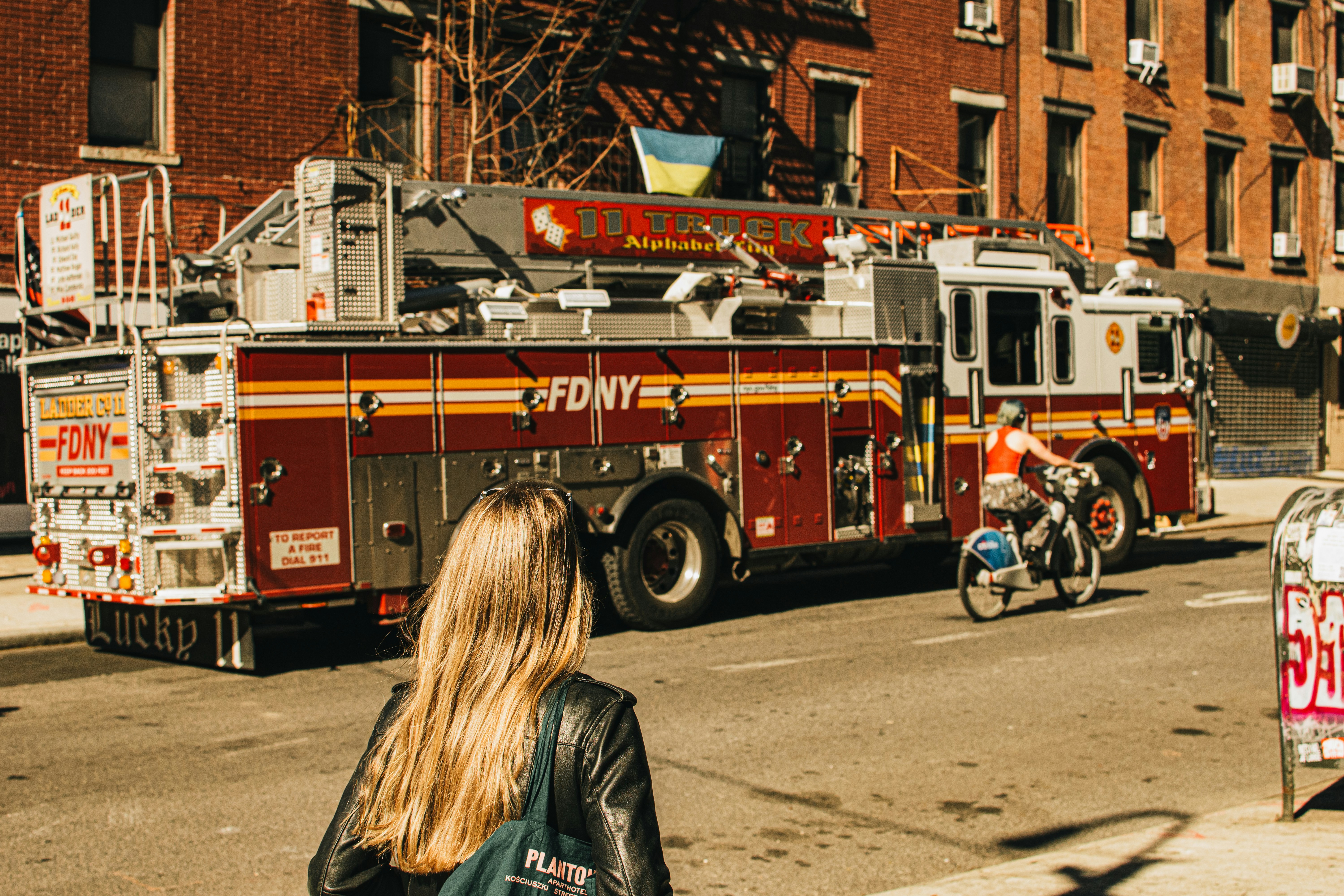Frontline in Focus: Fire Truck and Onlooker Amid Urban Heat