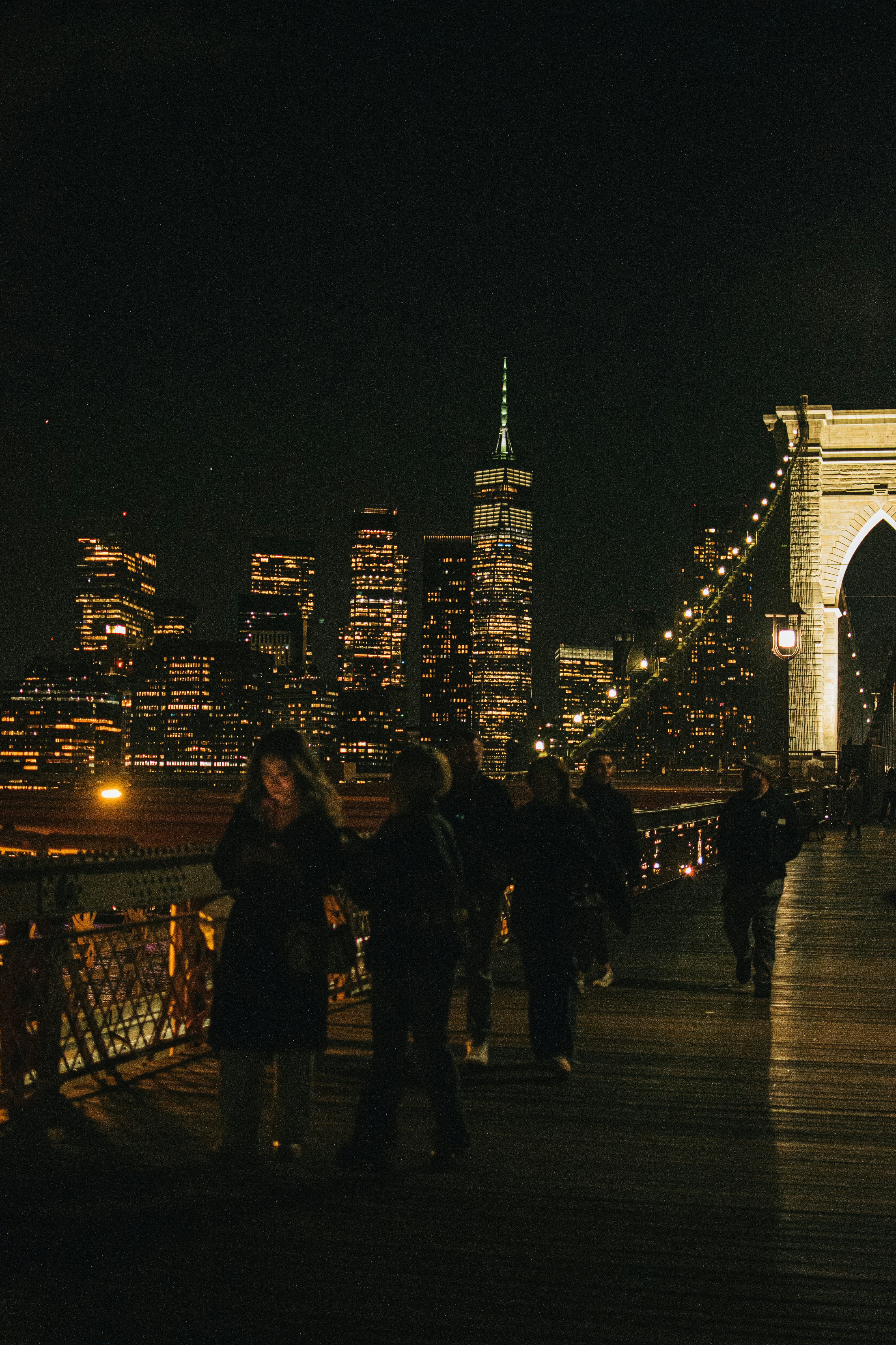 Night on the Brooklyn Bridge: Silhouetted Walkers Against a Luminous Skyline