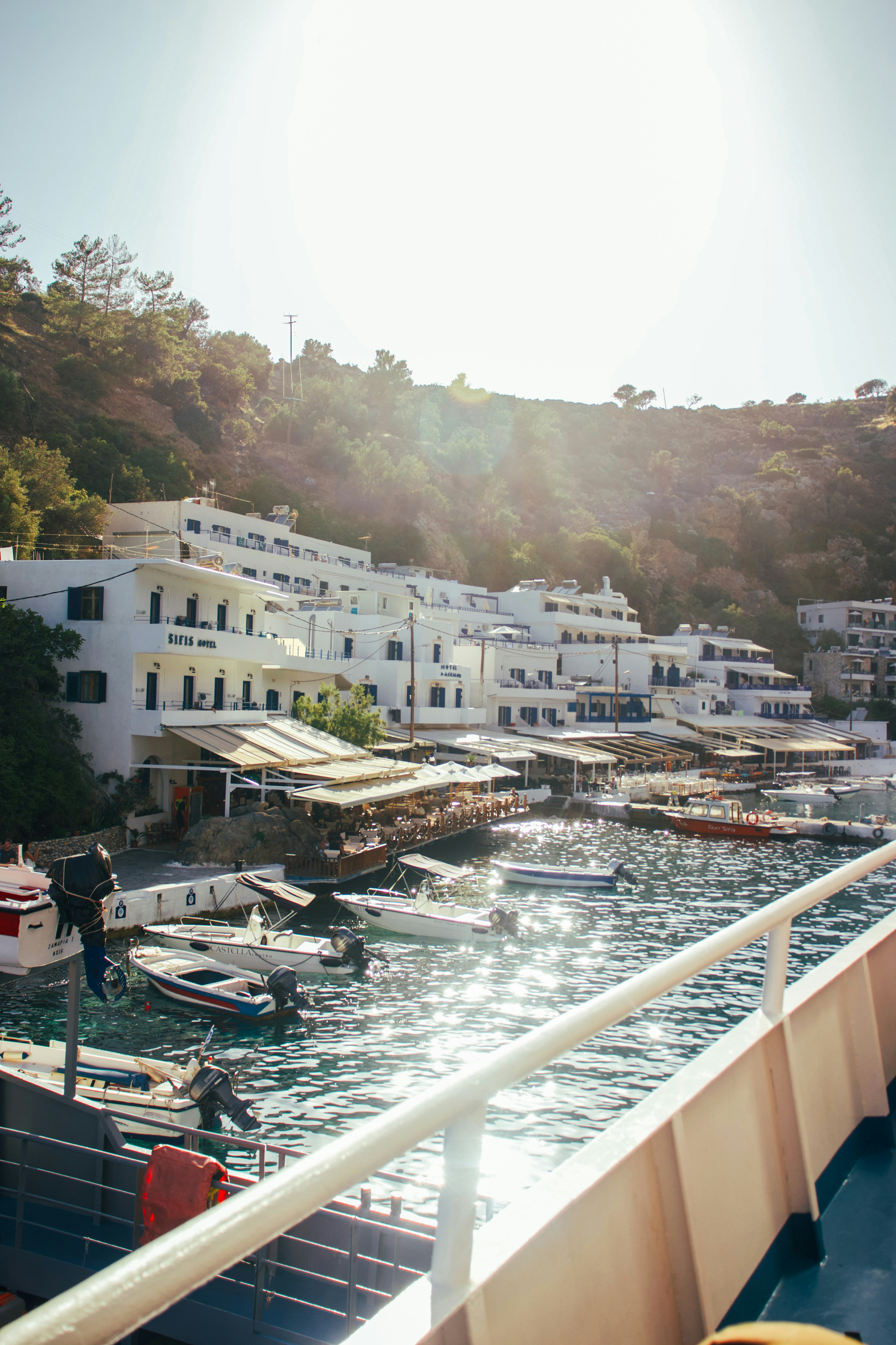 Sunlit harbor village casts shimmering glare over white-washed terraces