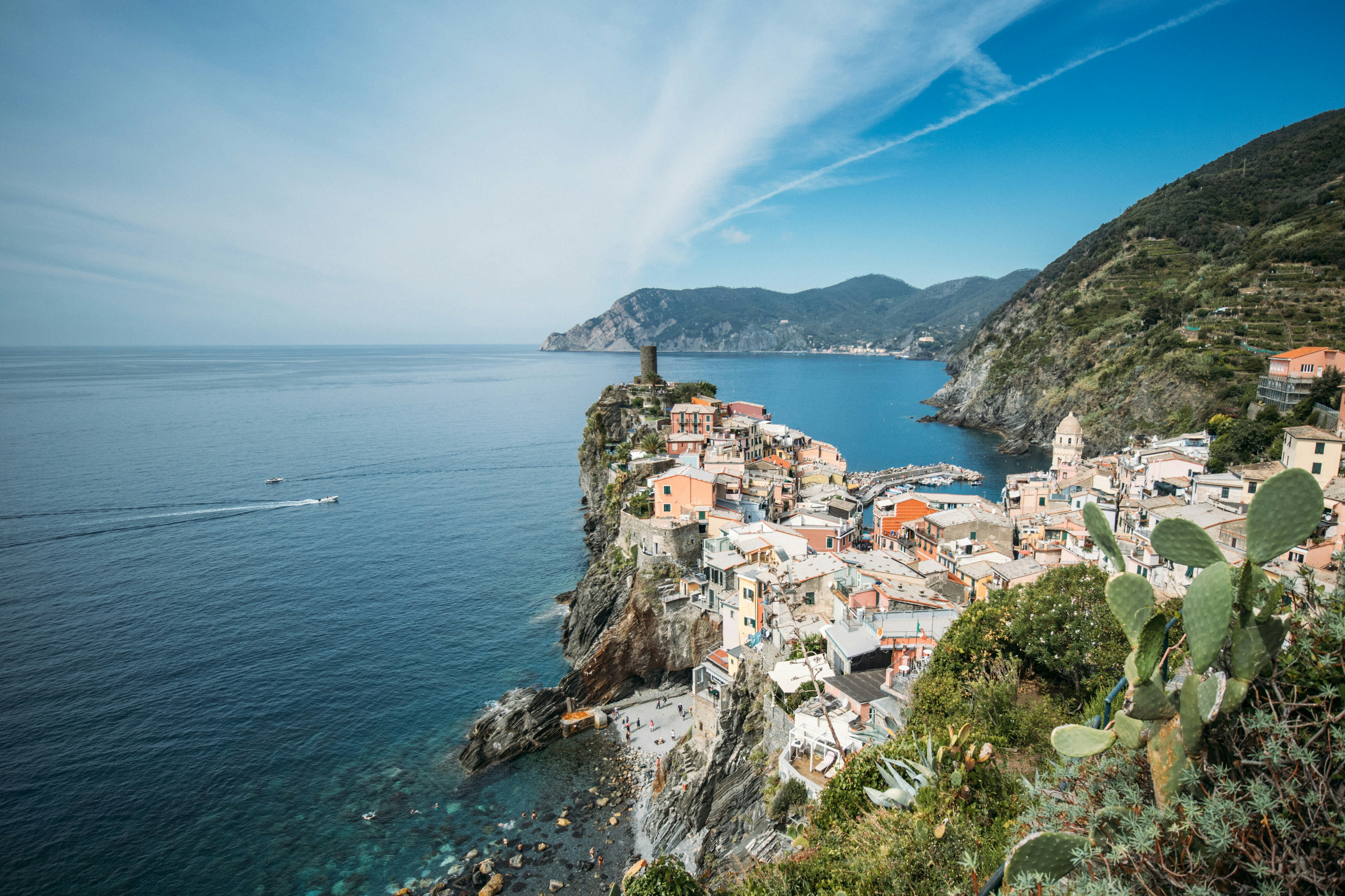  cliffside village of Vernazza anchored by a silhouette of a lighthouse on a dramatic overlook