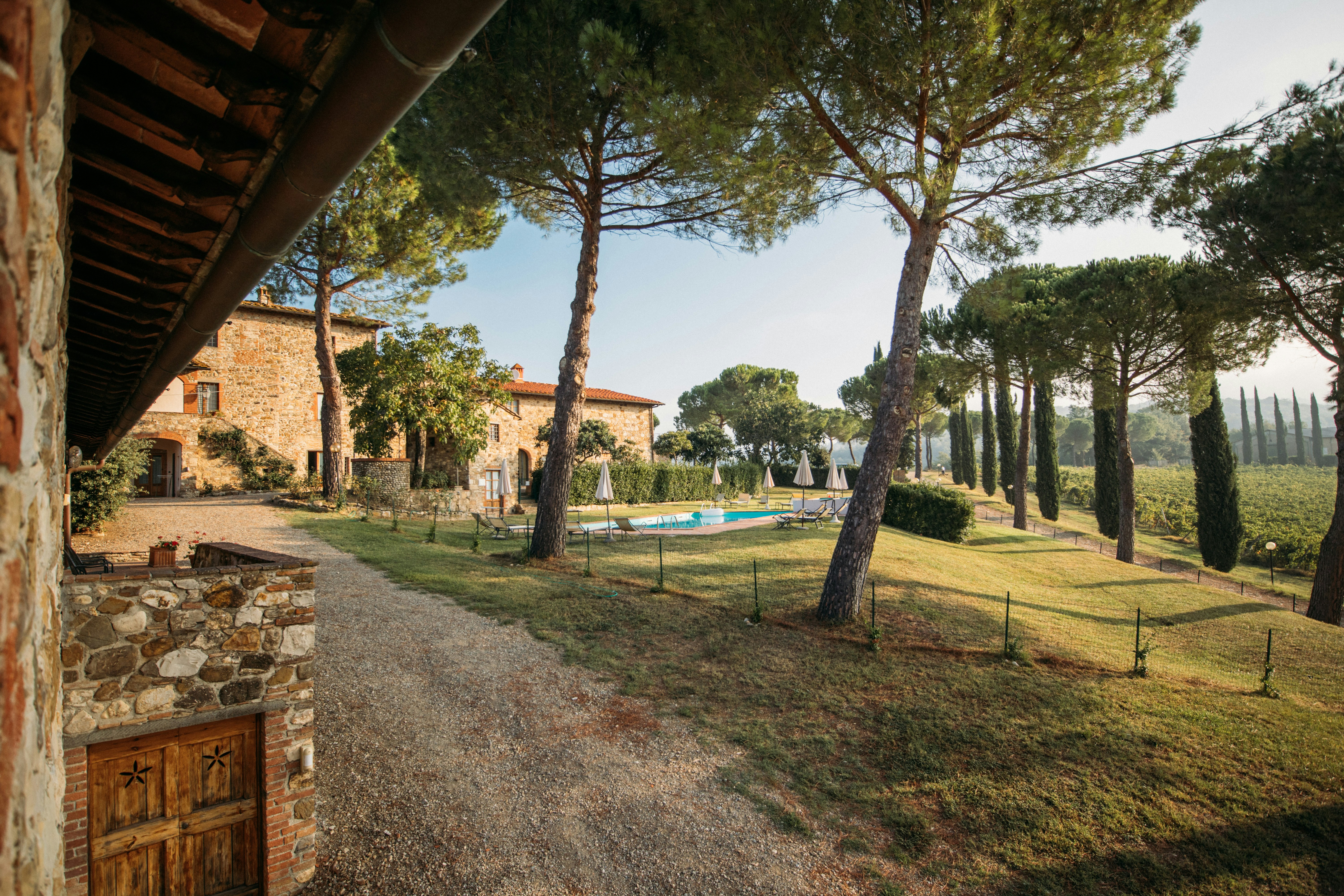 Sunlit Estate Across the Lawn with Pool and Pines