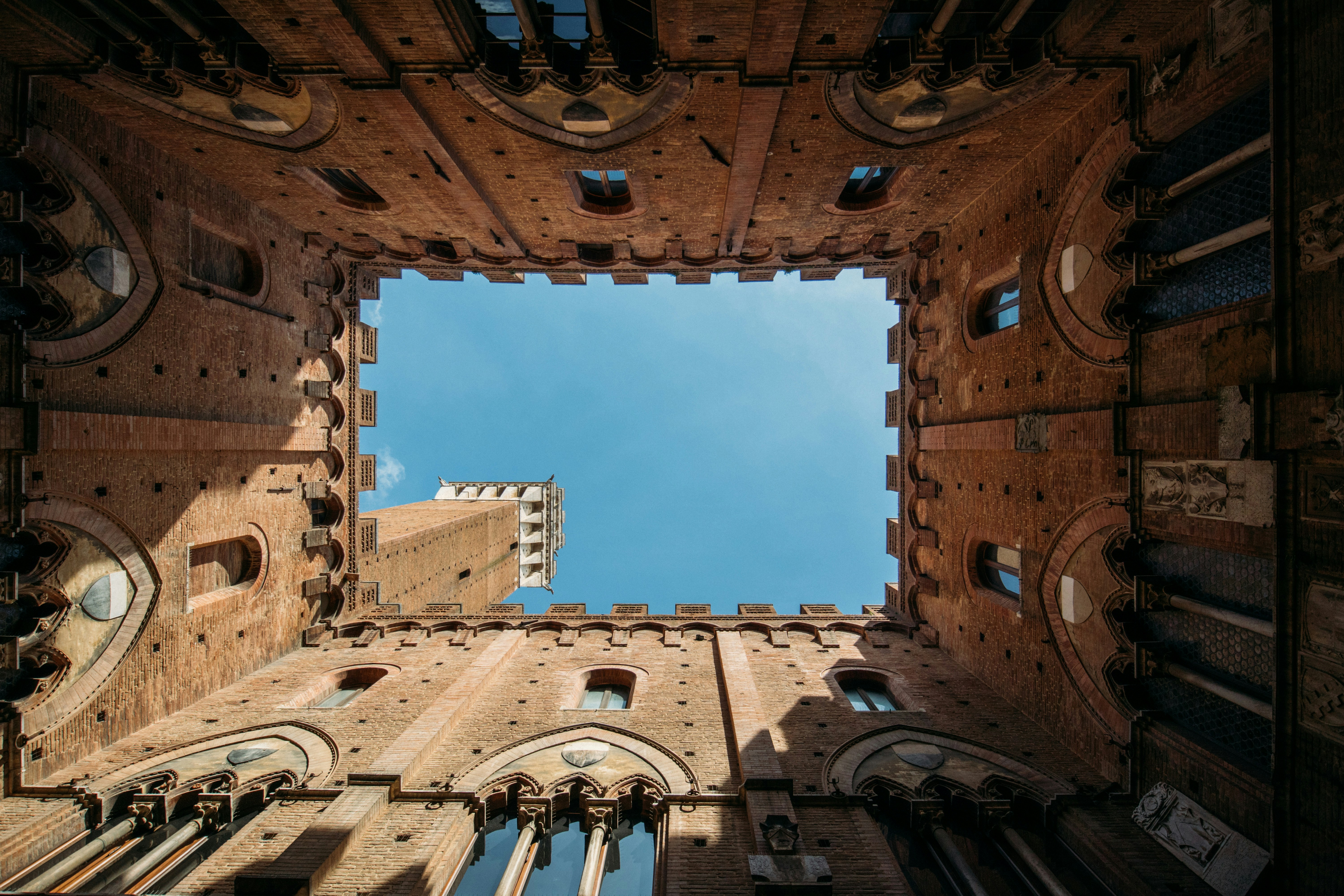 Sky Above the Brick Perimeter: A Turreted Atrium Framed by Archways