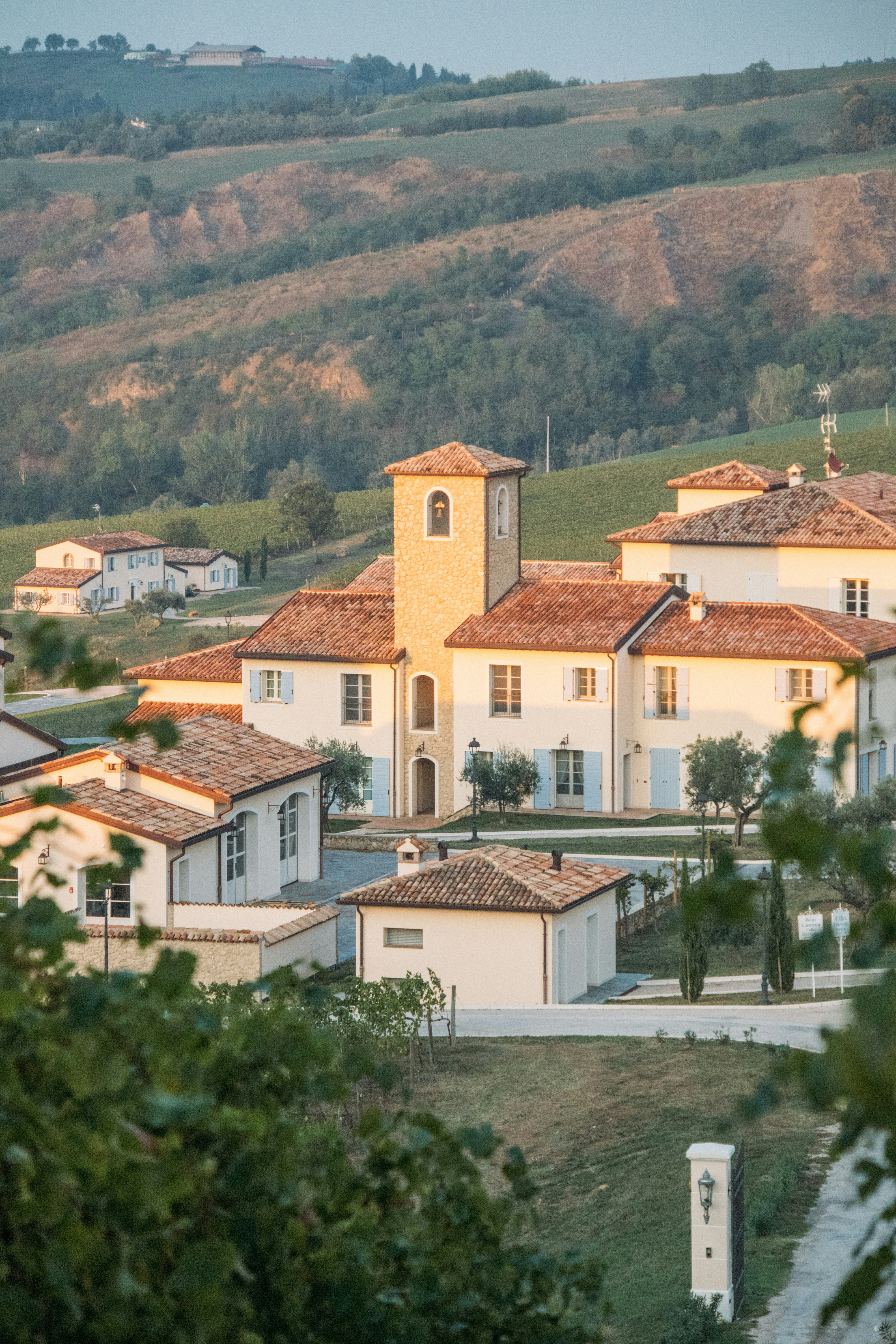 Sunlit Tuscan-like Village: Warm-Hued Buildings Against Rolling Hills