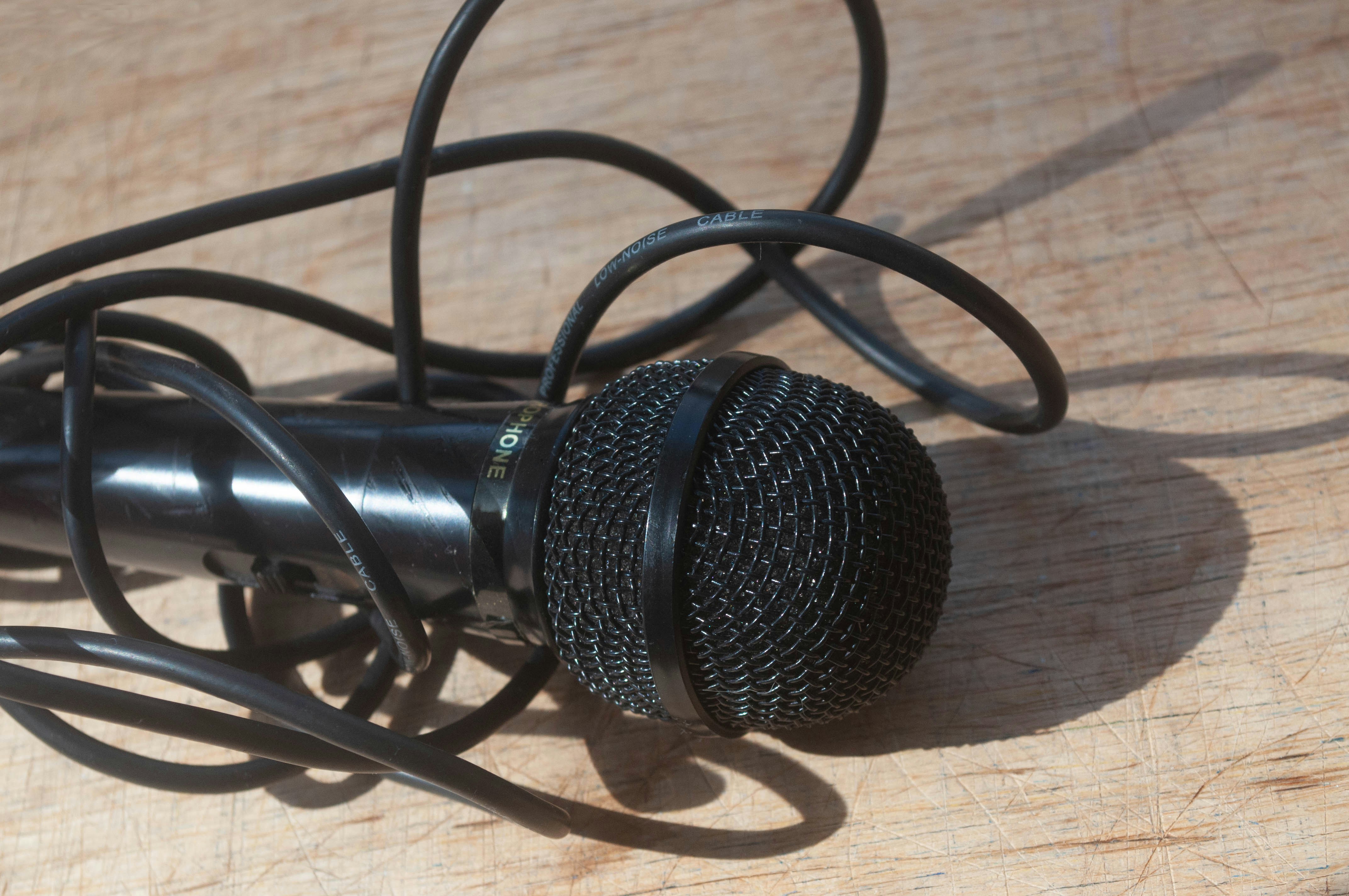Entangled Mic: A Close-Up of a Shattered Cables Microphone on Wood