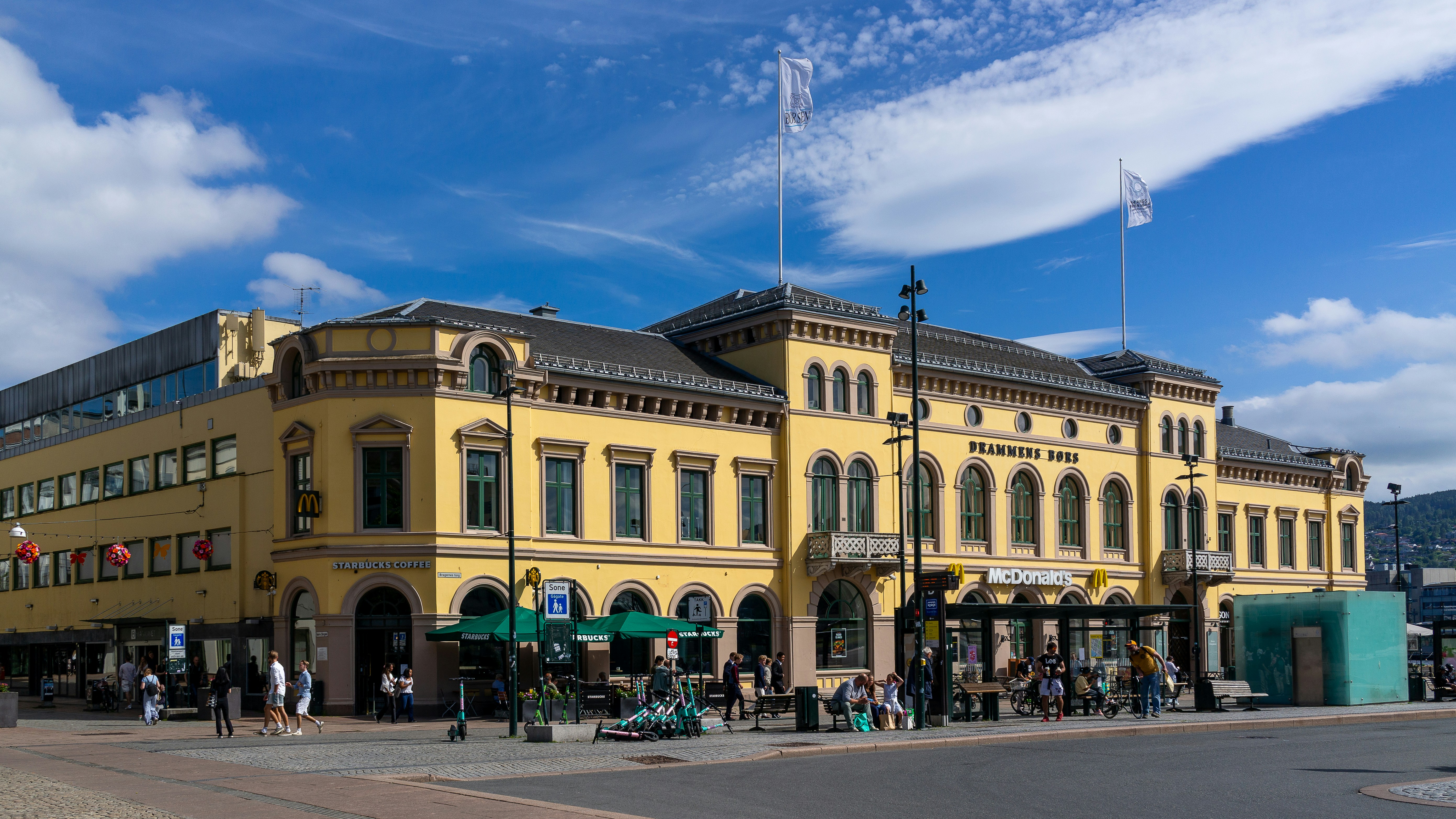 Sunlit Façade of Fribourg Station: A Yellow Classical Corner