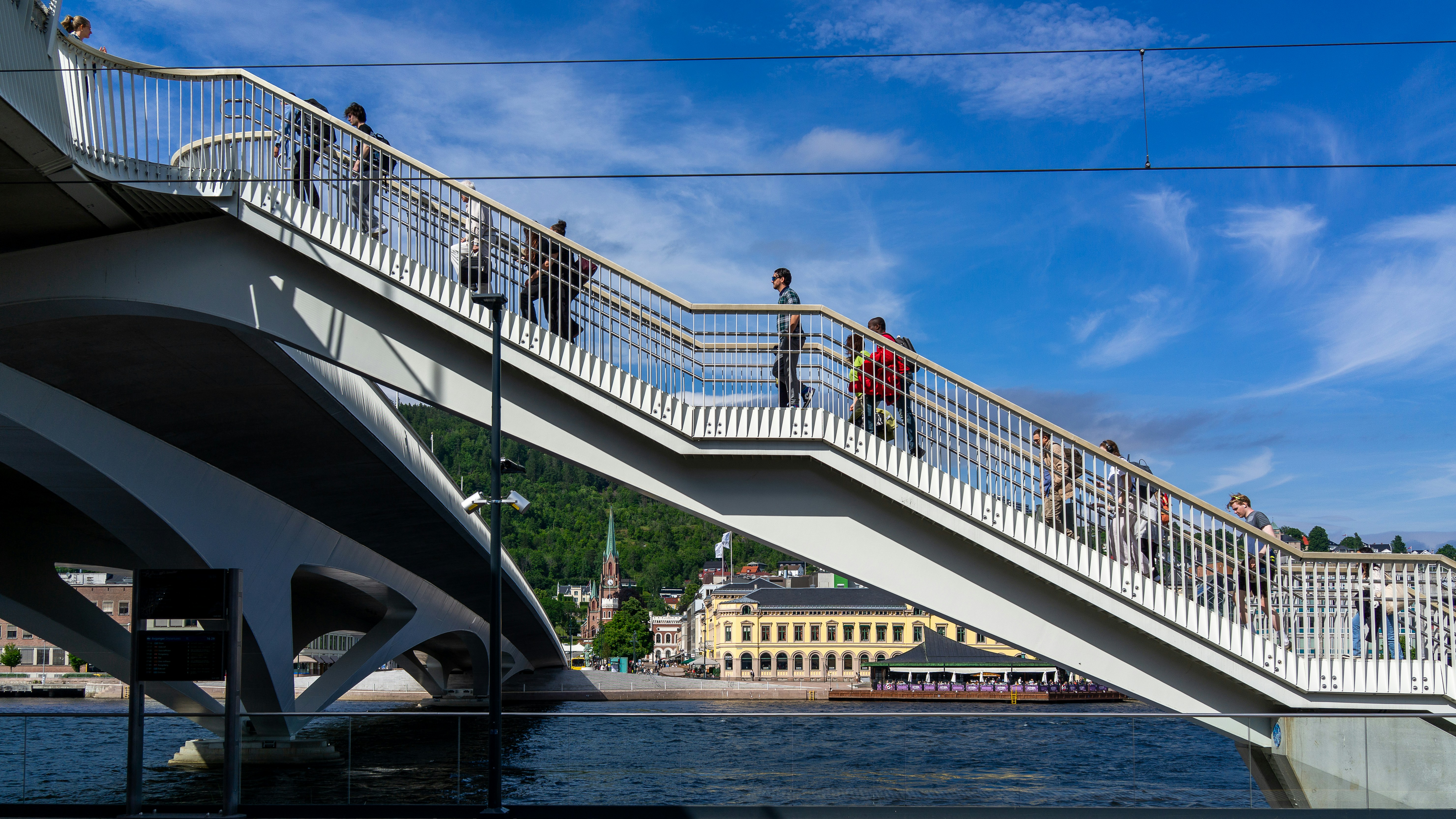 Crossing over: A sunlit pedestrian bridge above a river