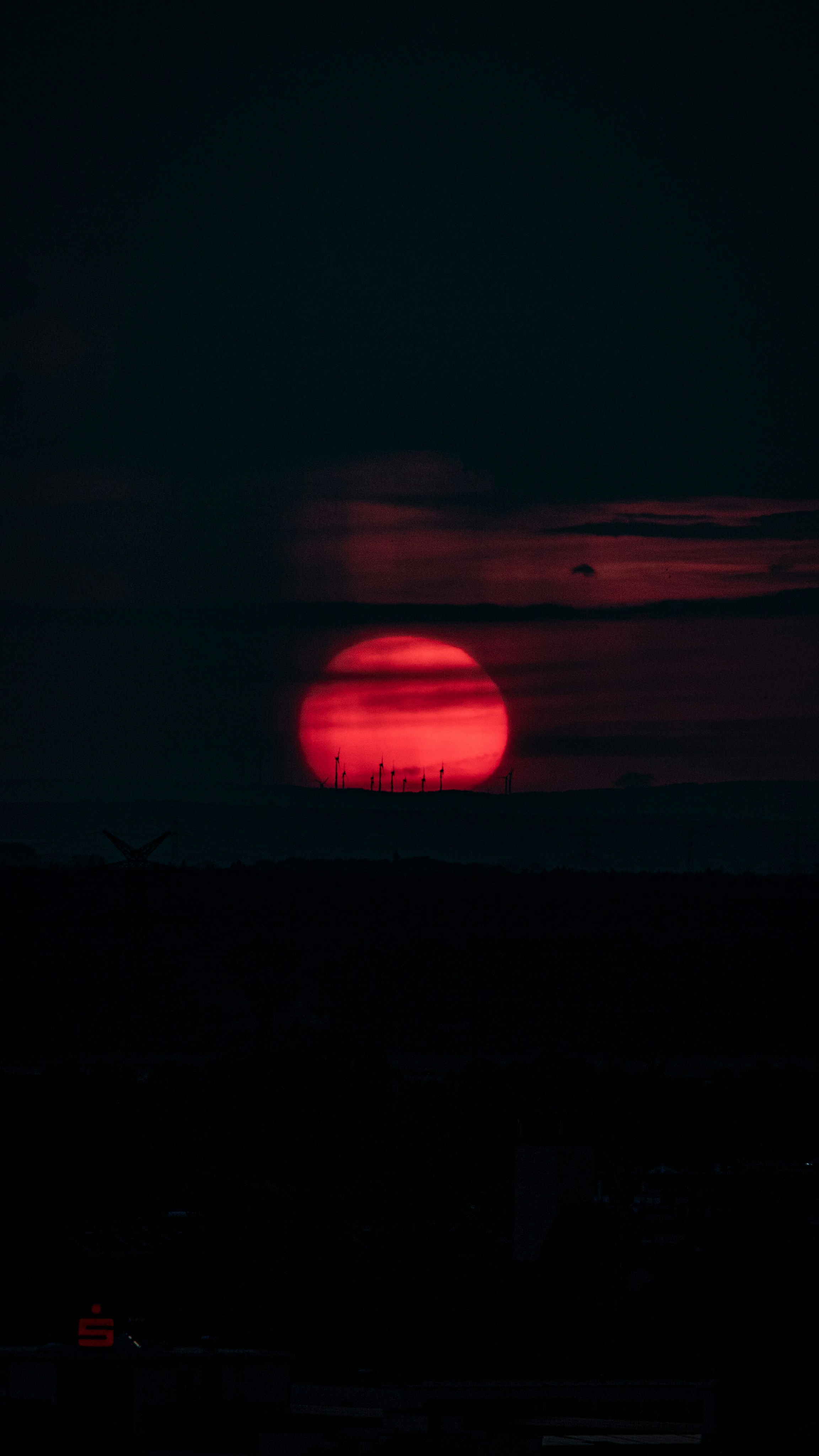  crimson horizon: a low-contrast sunset of a red sun sinking behind a quiet ridge
