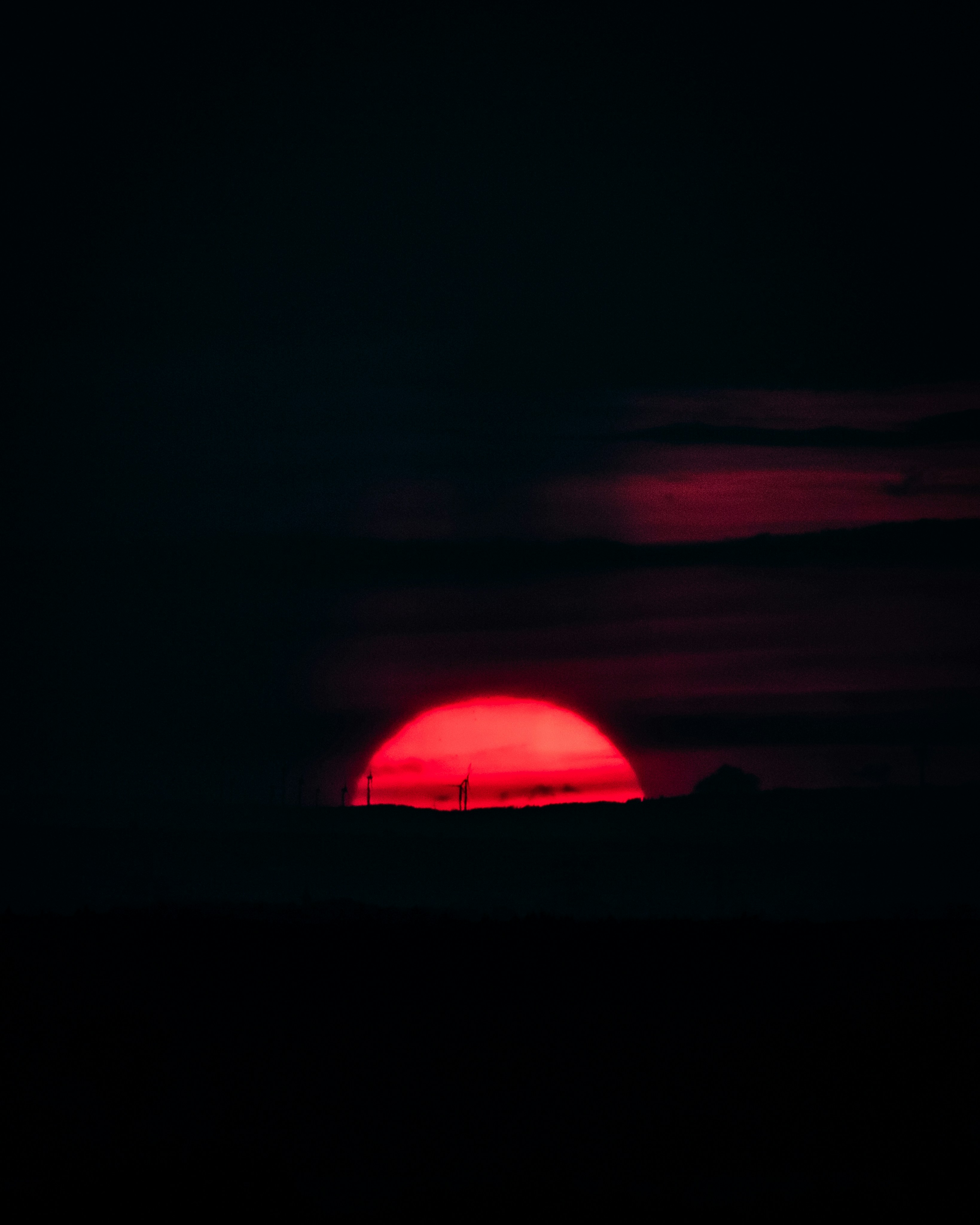 Red Dawn on the Horizon: A Night Sunset Dips Beneath the Ridge