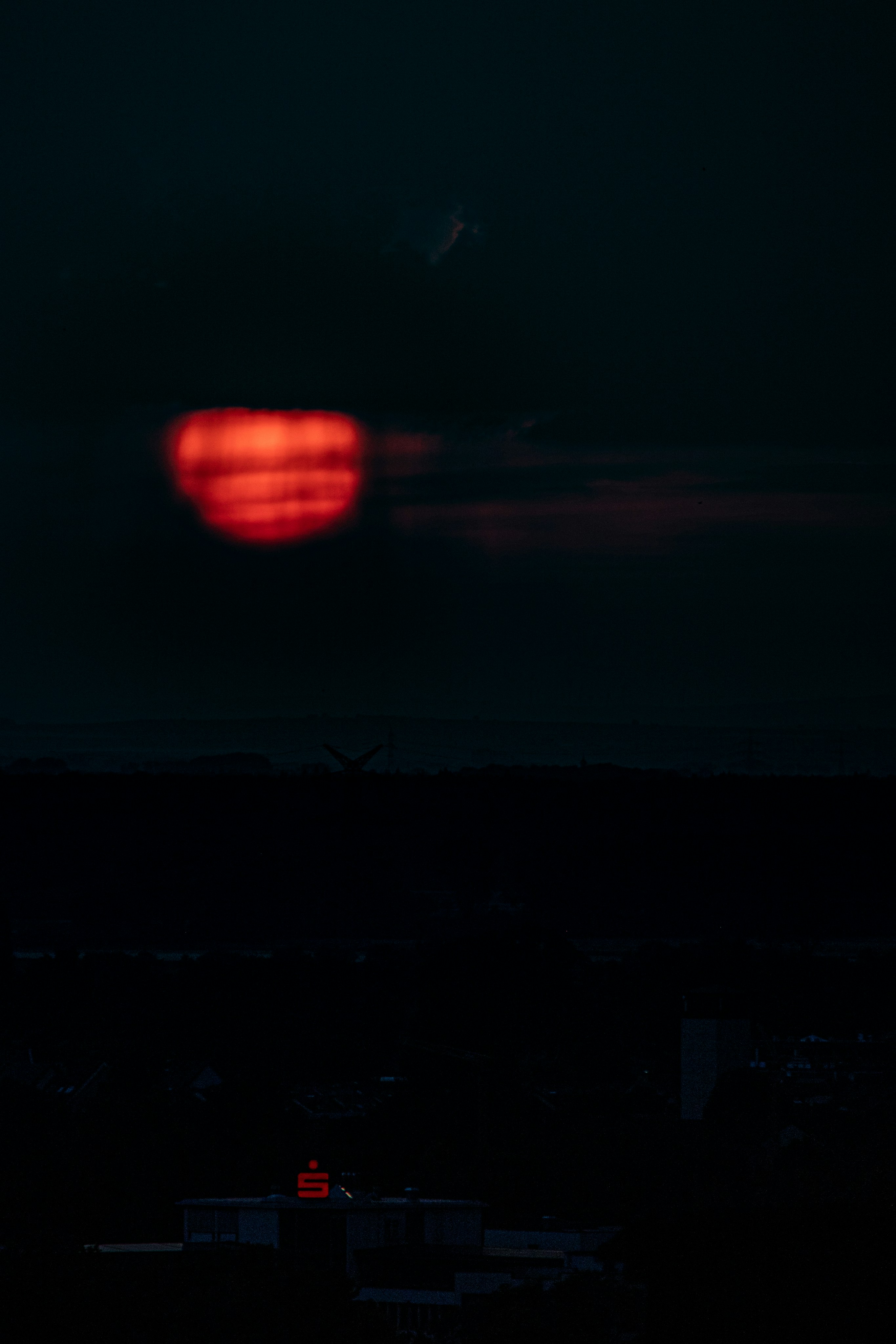 Red Sun at Distant Horizon over a Quiet Town