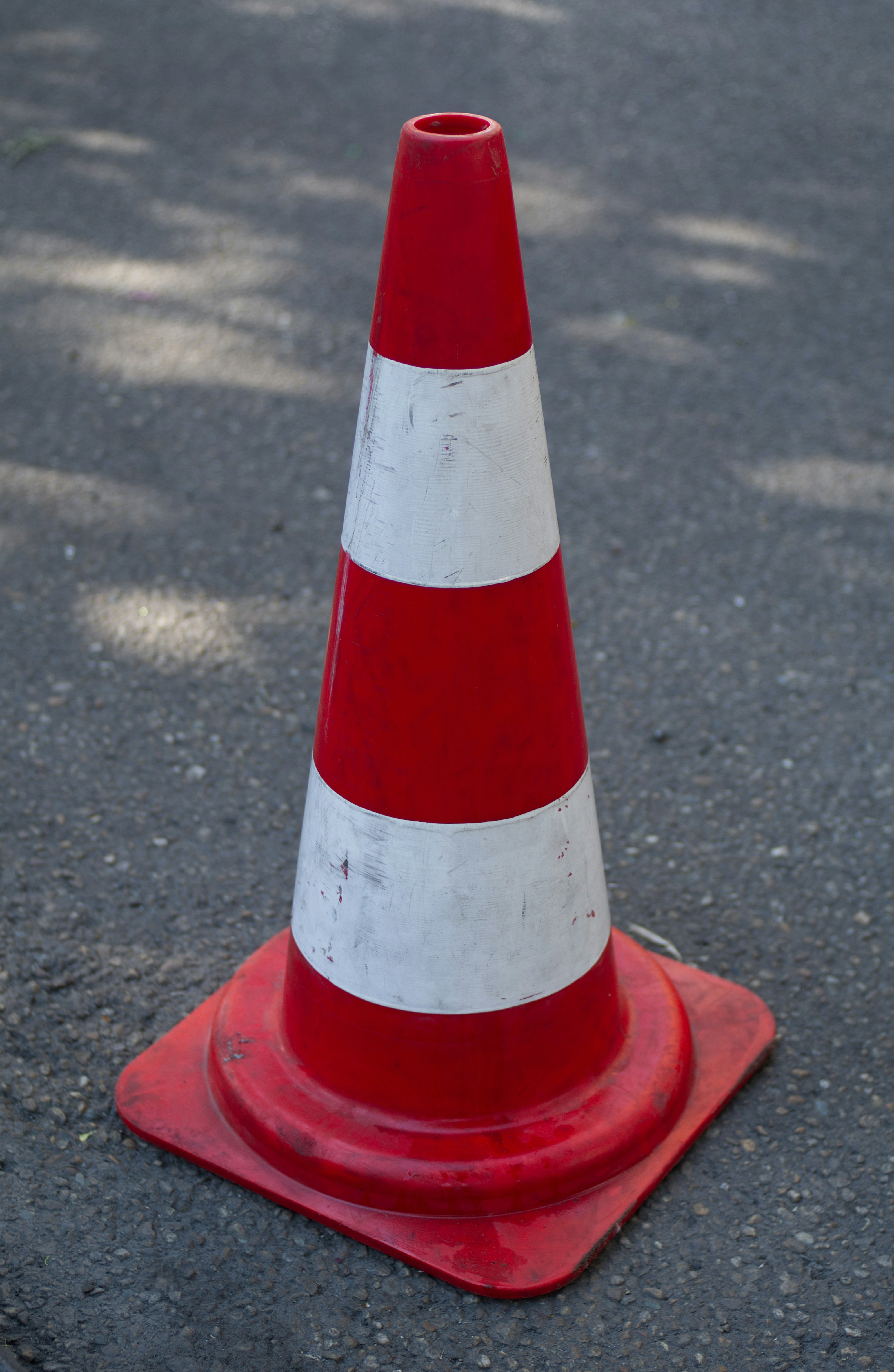 Standby Marker: A Solo Traffic Cone Anchored on Asphalt