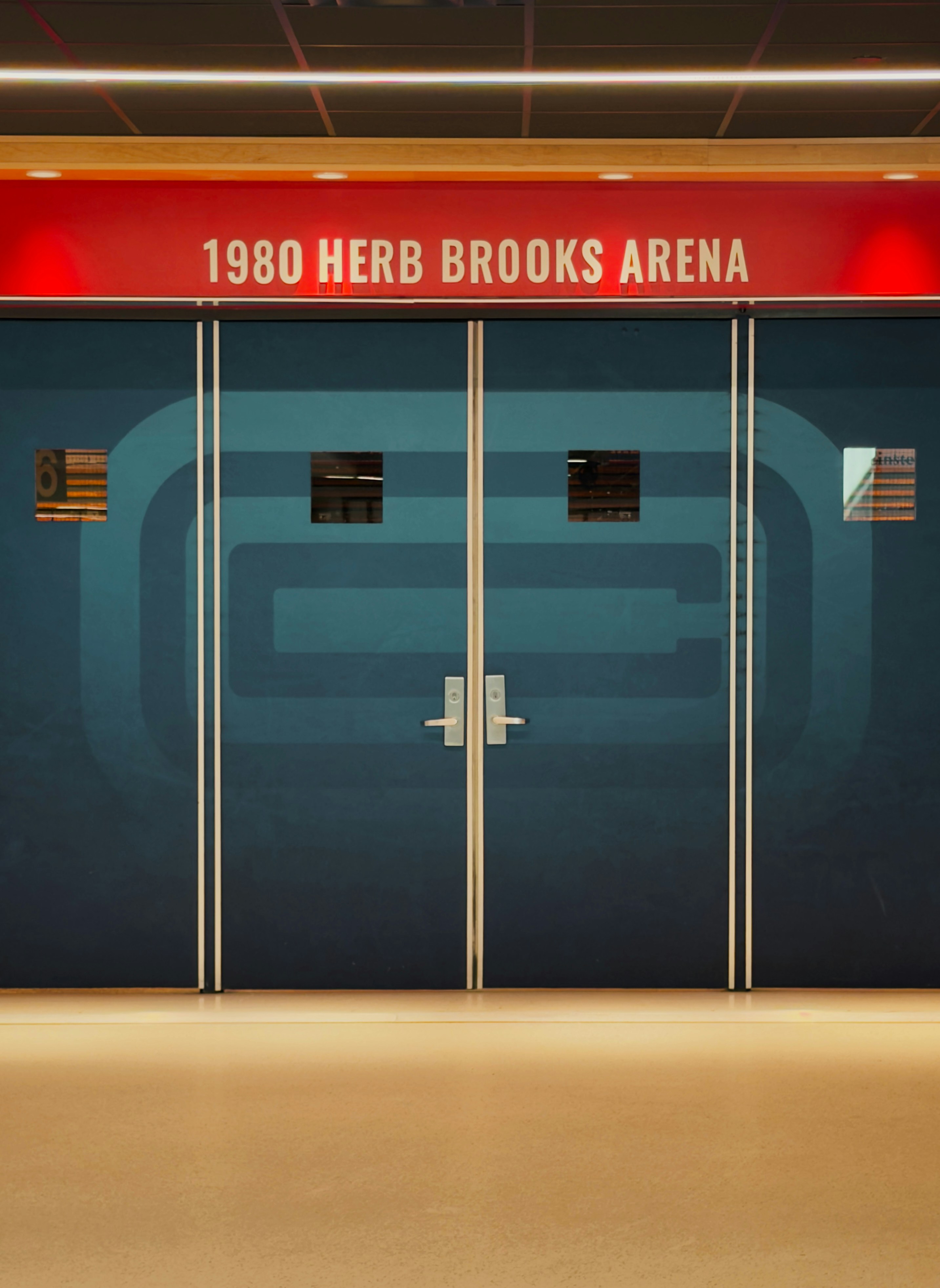 Doors of the Arena: Bold Blue Panels and Red Sign