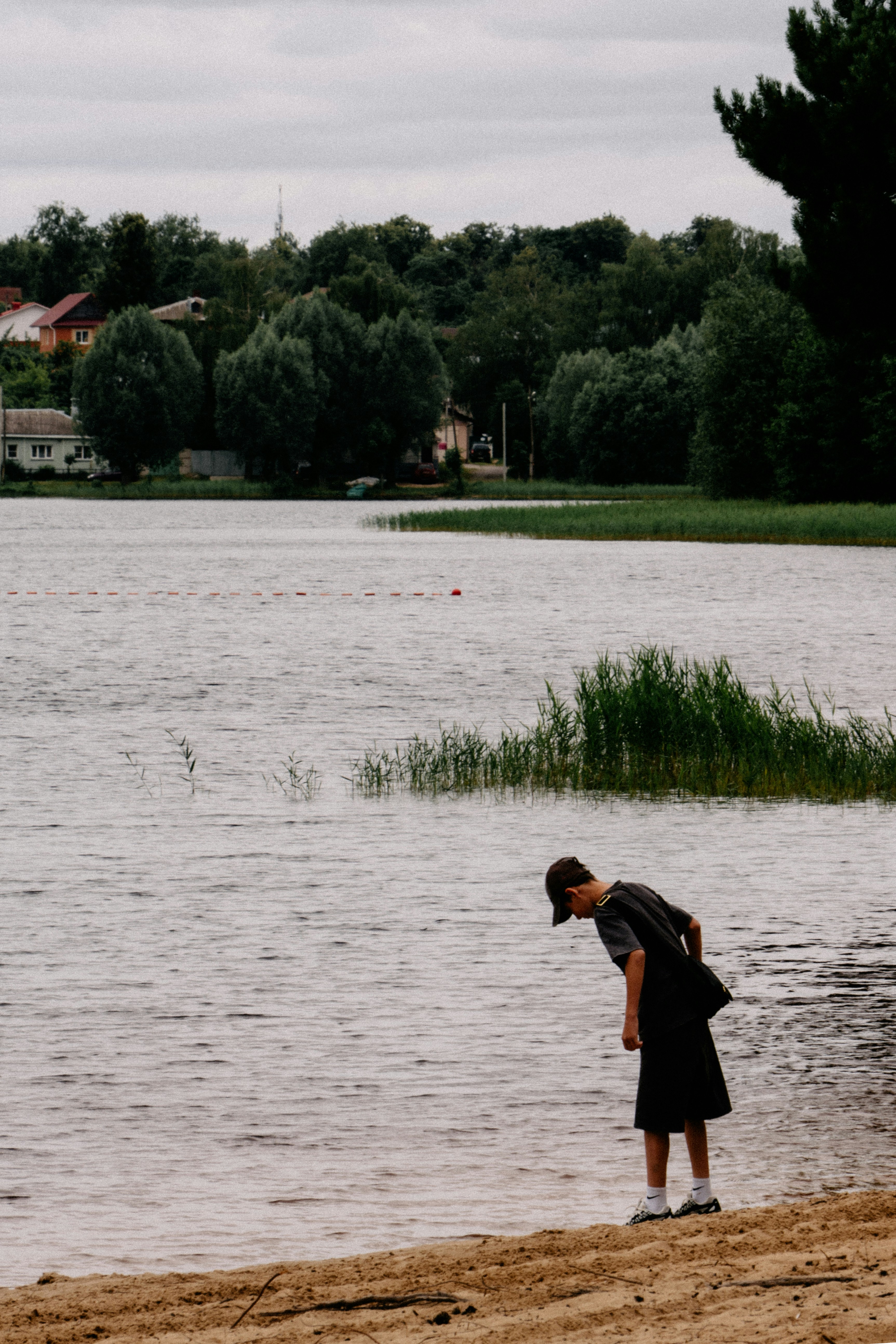 A Quiet Shore: Boy in a Black School Uniform By the Water