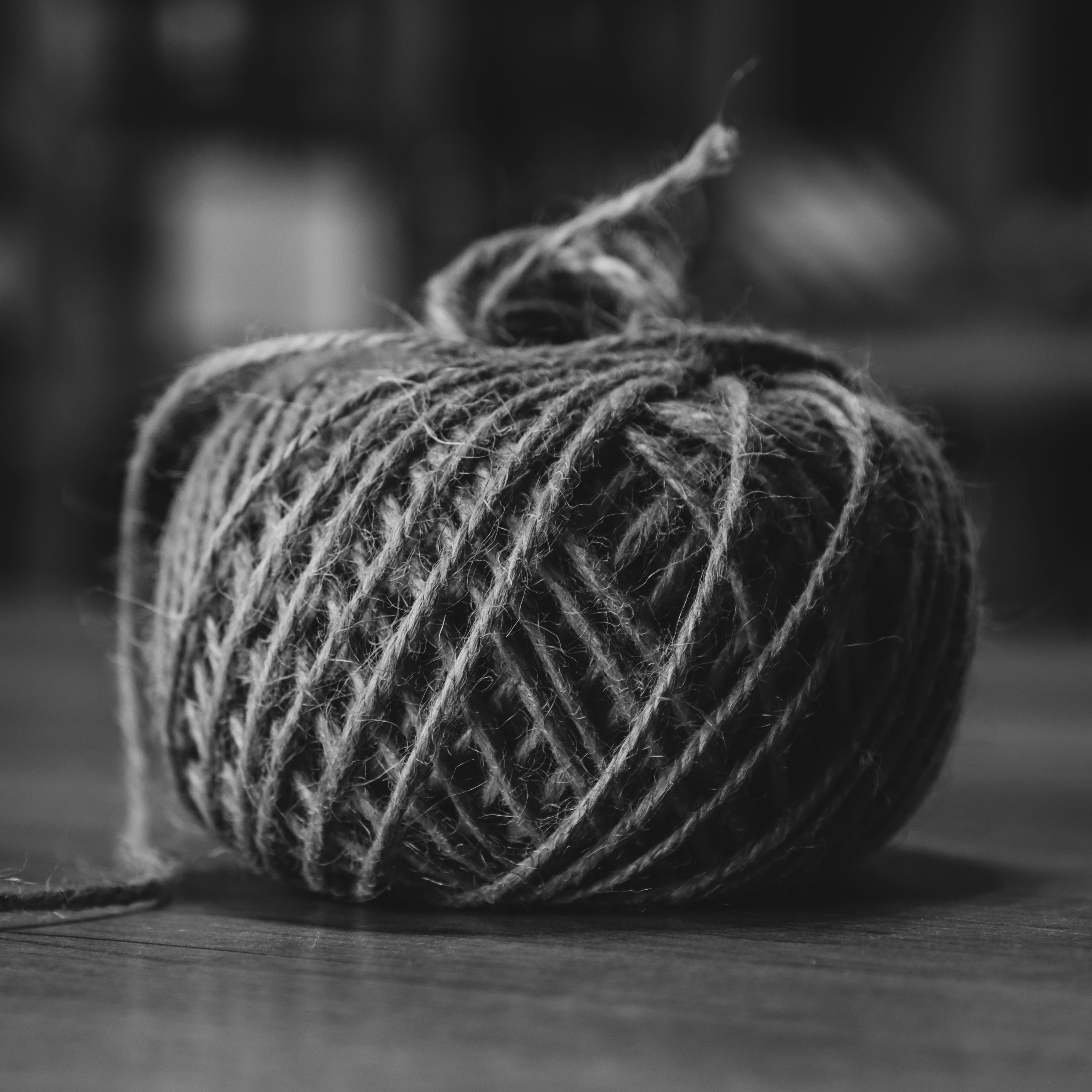 Twine in Focus: A Coiled Ball of Jute Resting on a Wooden Surface
