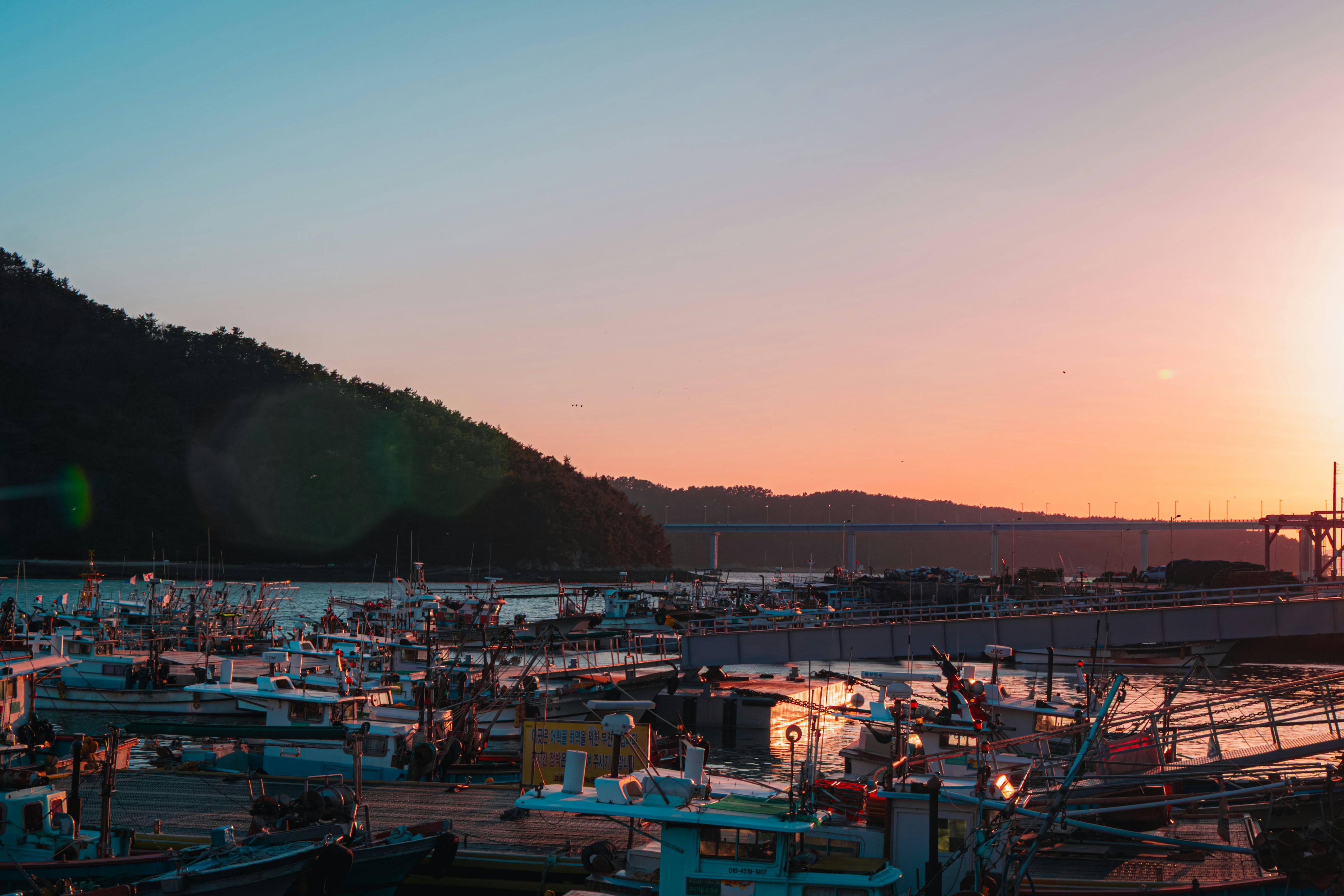 Golden Hour in the Docks: Boats Silhouetted against a Slowing Sun