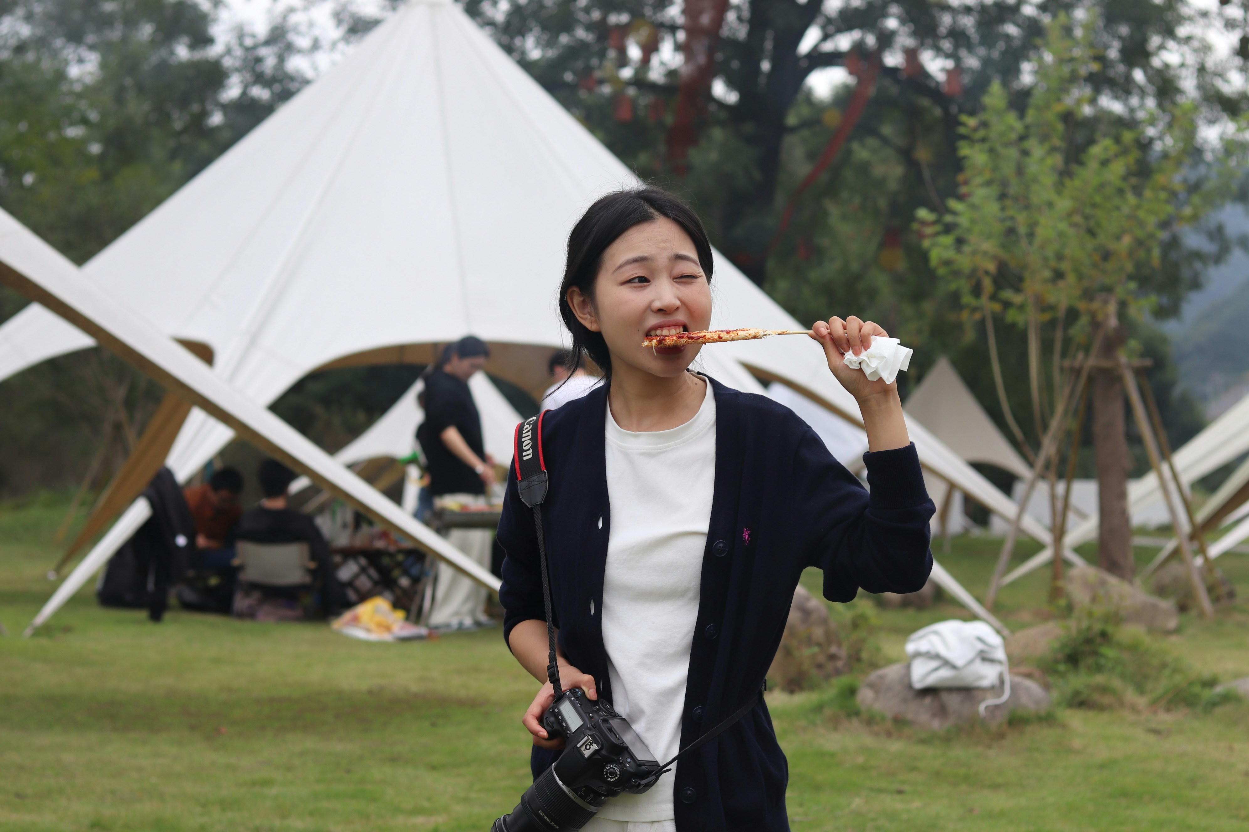 Midfield Snack Break: Portrait of a photographer in motion at a campsite